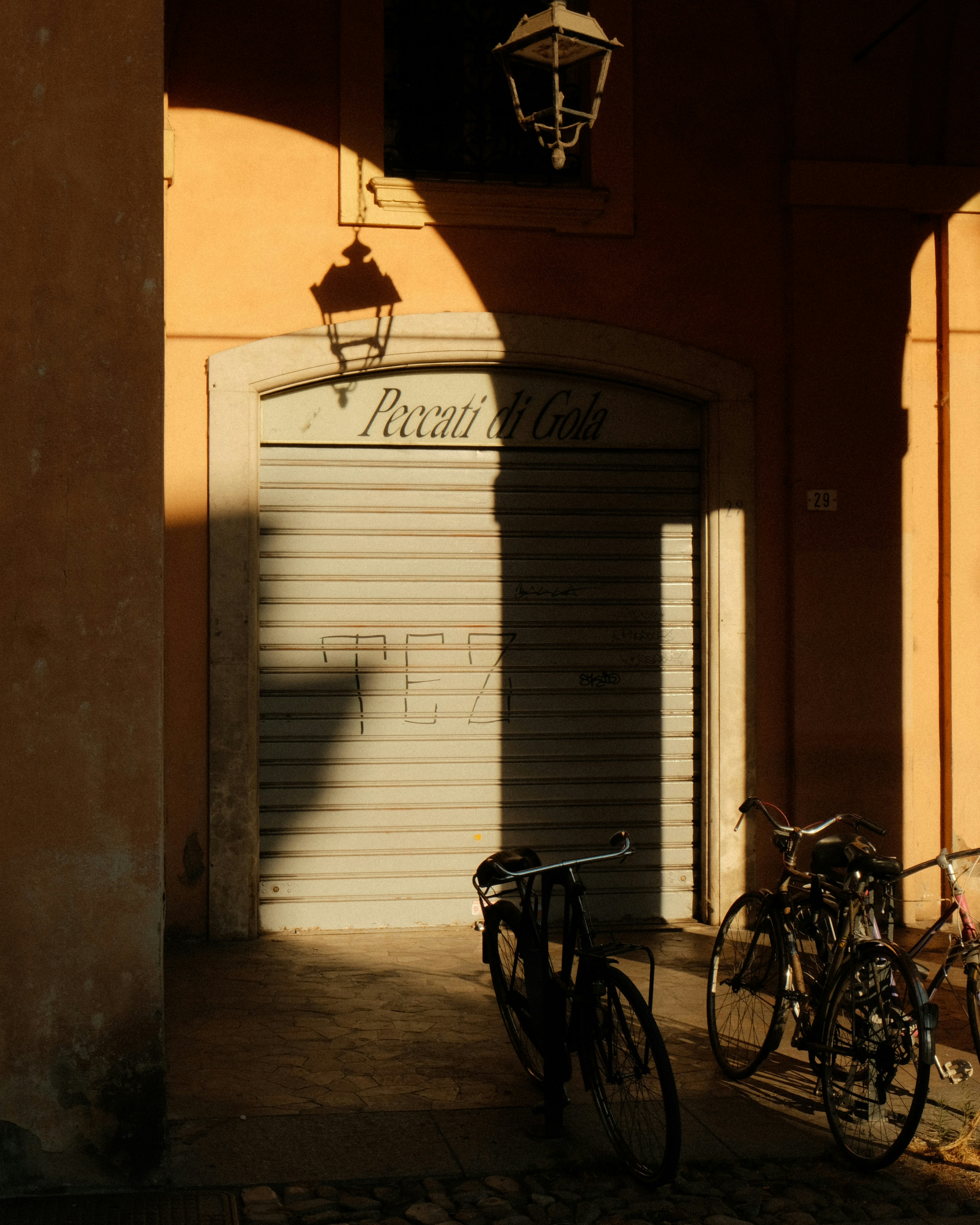 Shadows and bikes frame a sunlit facade. photo – Free Street photography Image on Unsplash