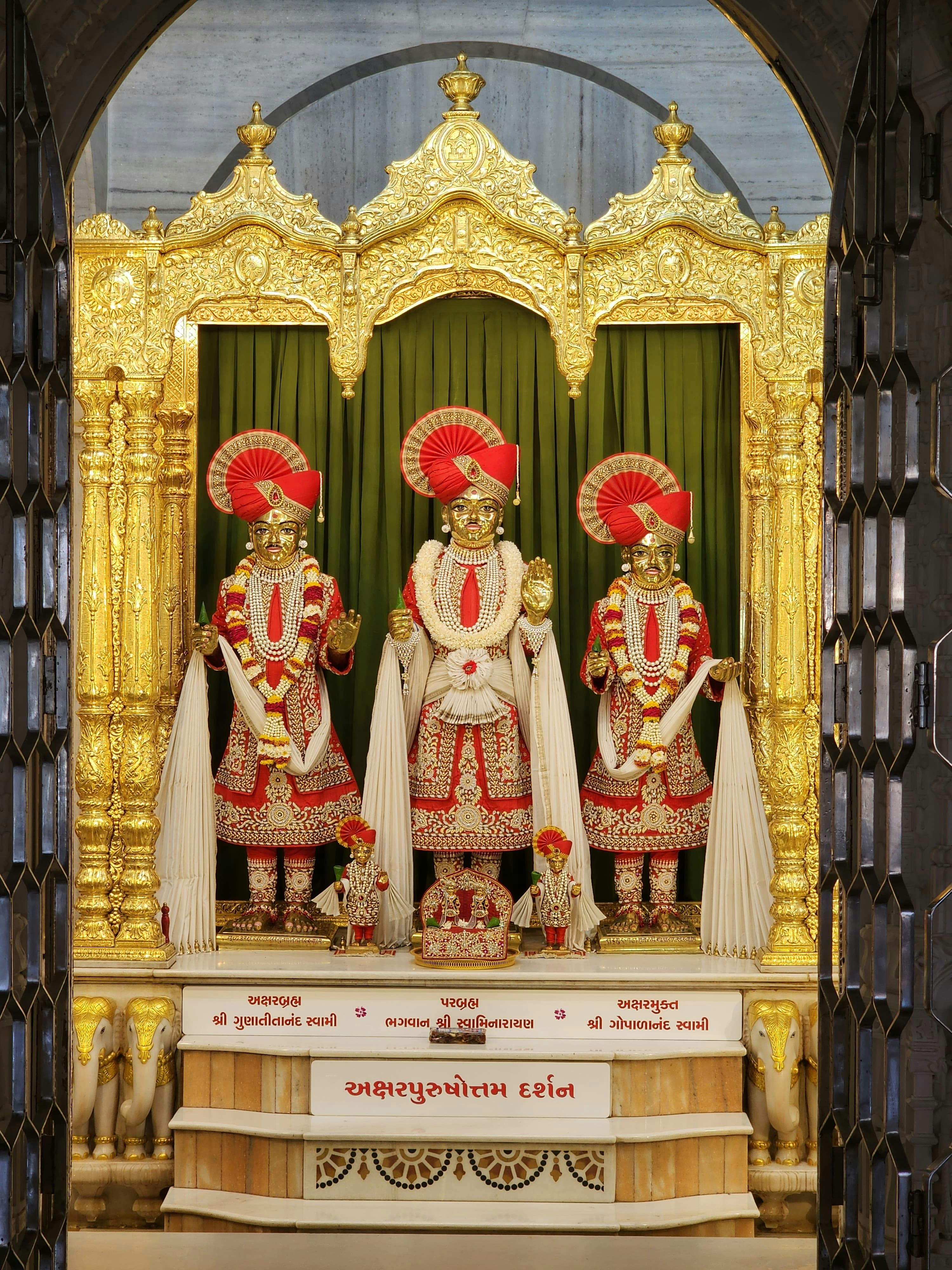 Three decorated deities are displayed within a temple. photo – Free ...