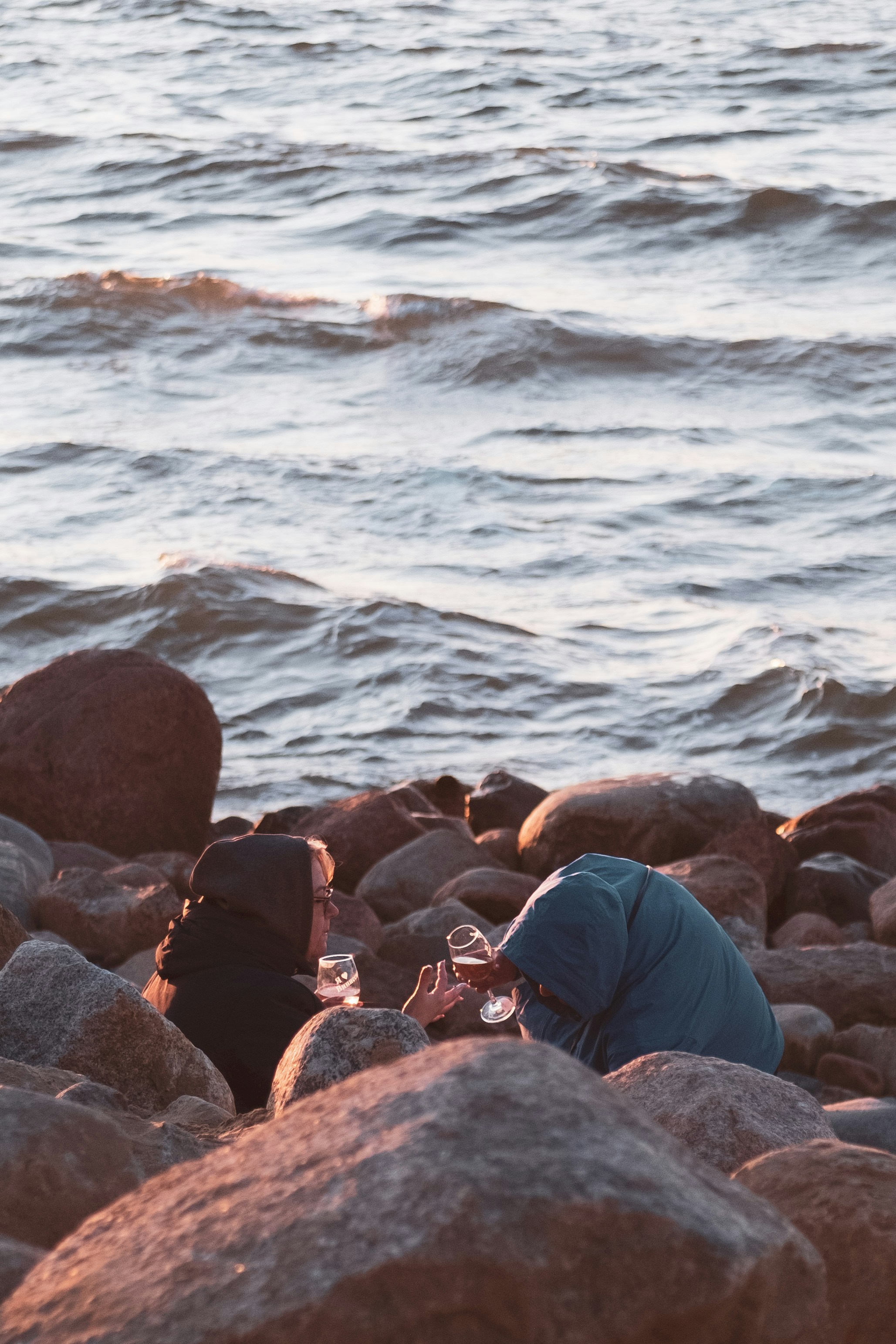 Friends enjoy wine by the ocean.