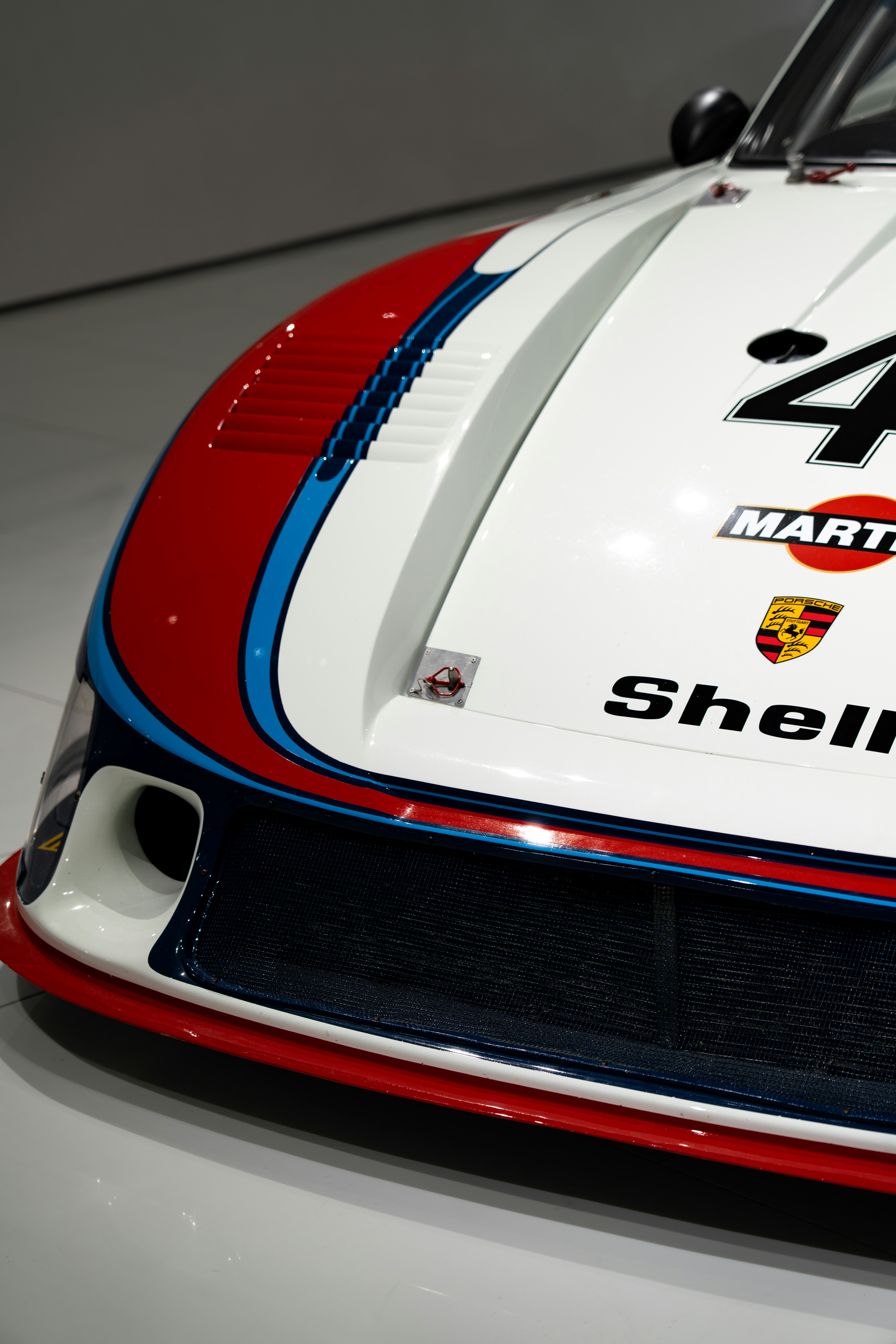 Close-up of a classic Porsche race car showcasing its vibrant livery and distinctive features. The image highlights the intricate design elements and branding.