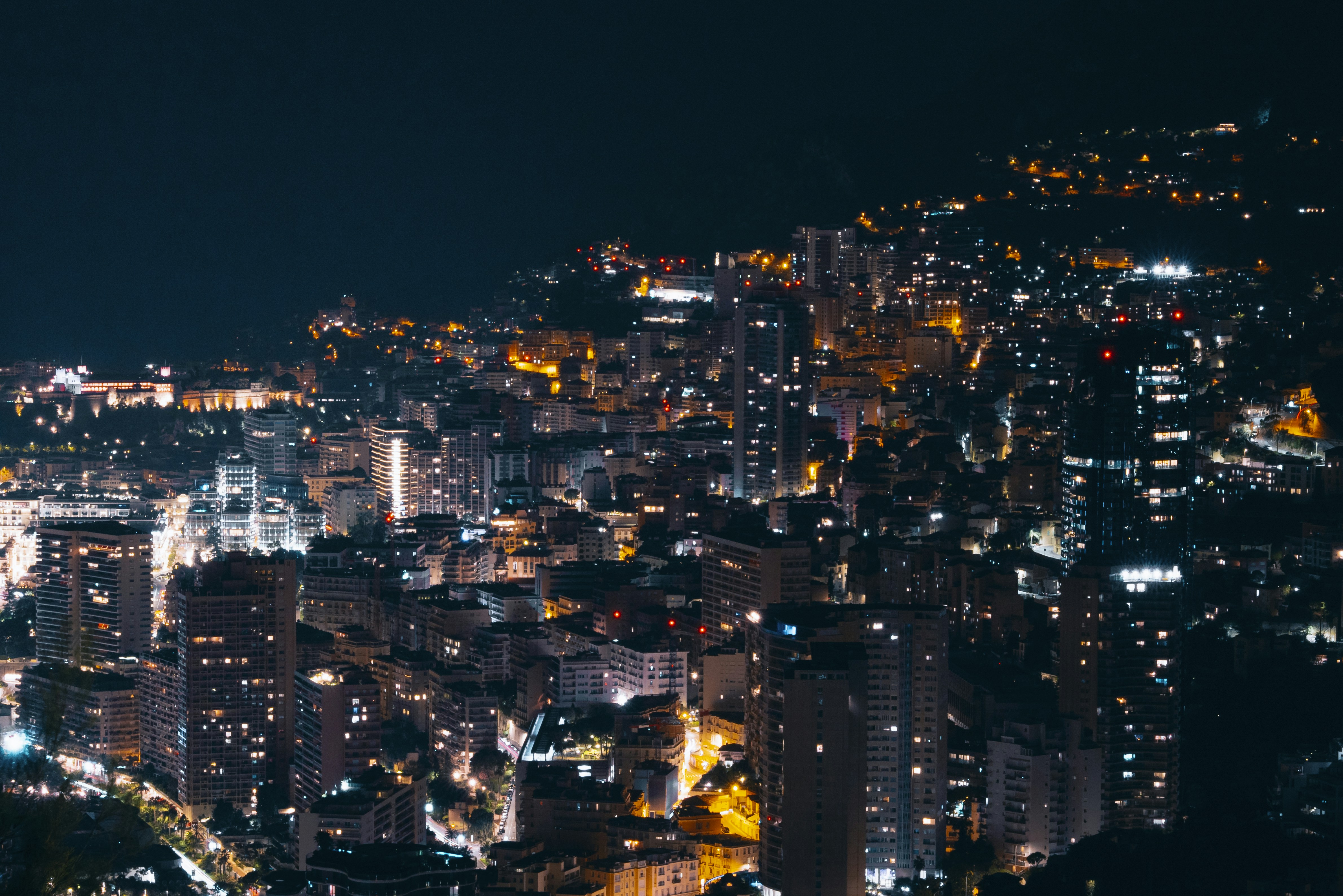 Vibrant cityscape illuminated by countless lights against a dark night sky, showcasing urban life and architecture.