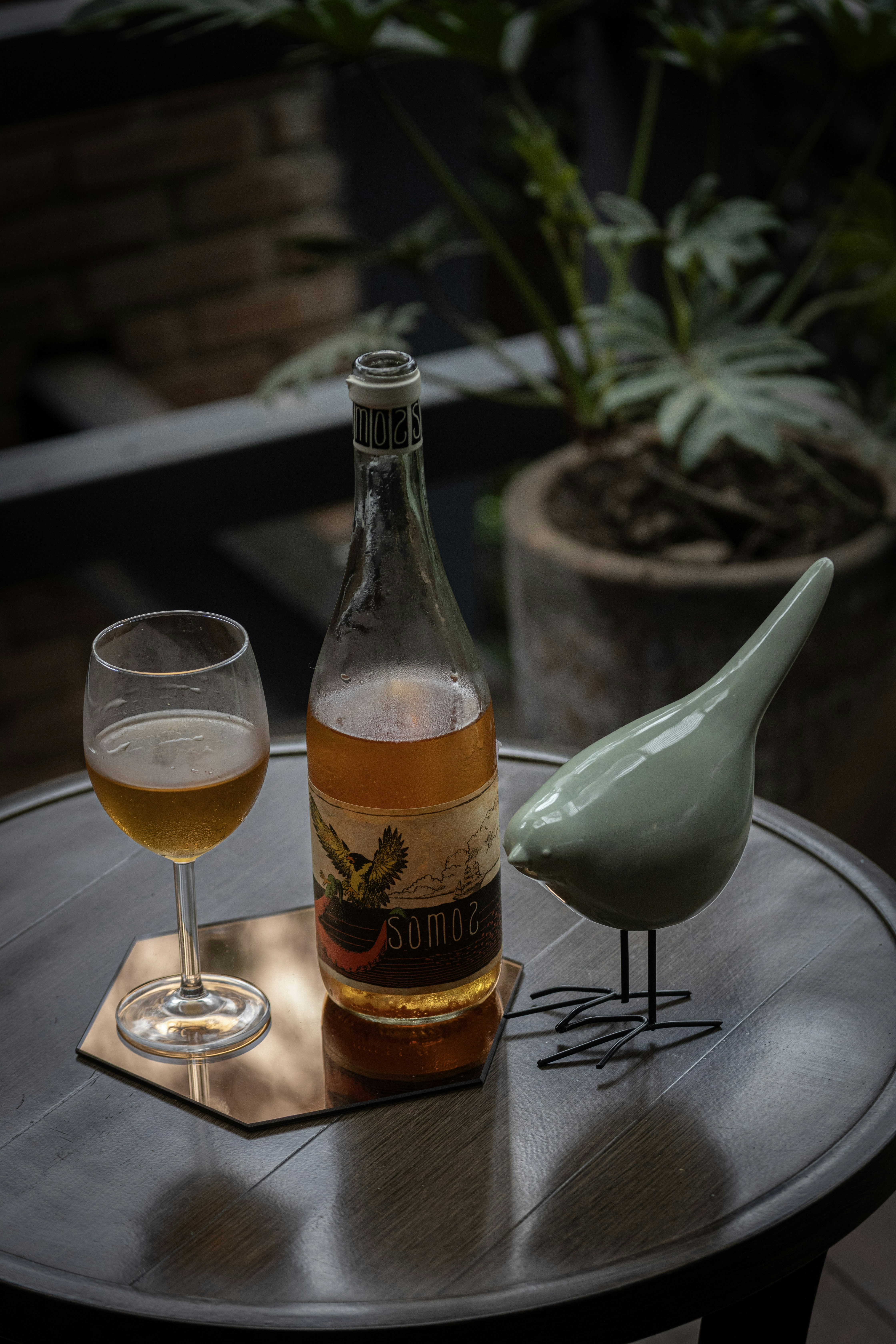 A glass and bottle rest on an outdoor table. photo – Free Furniture ...