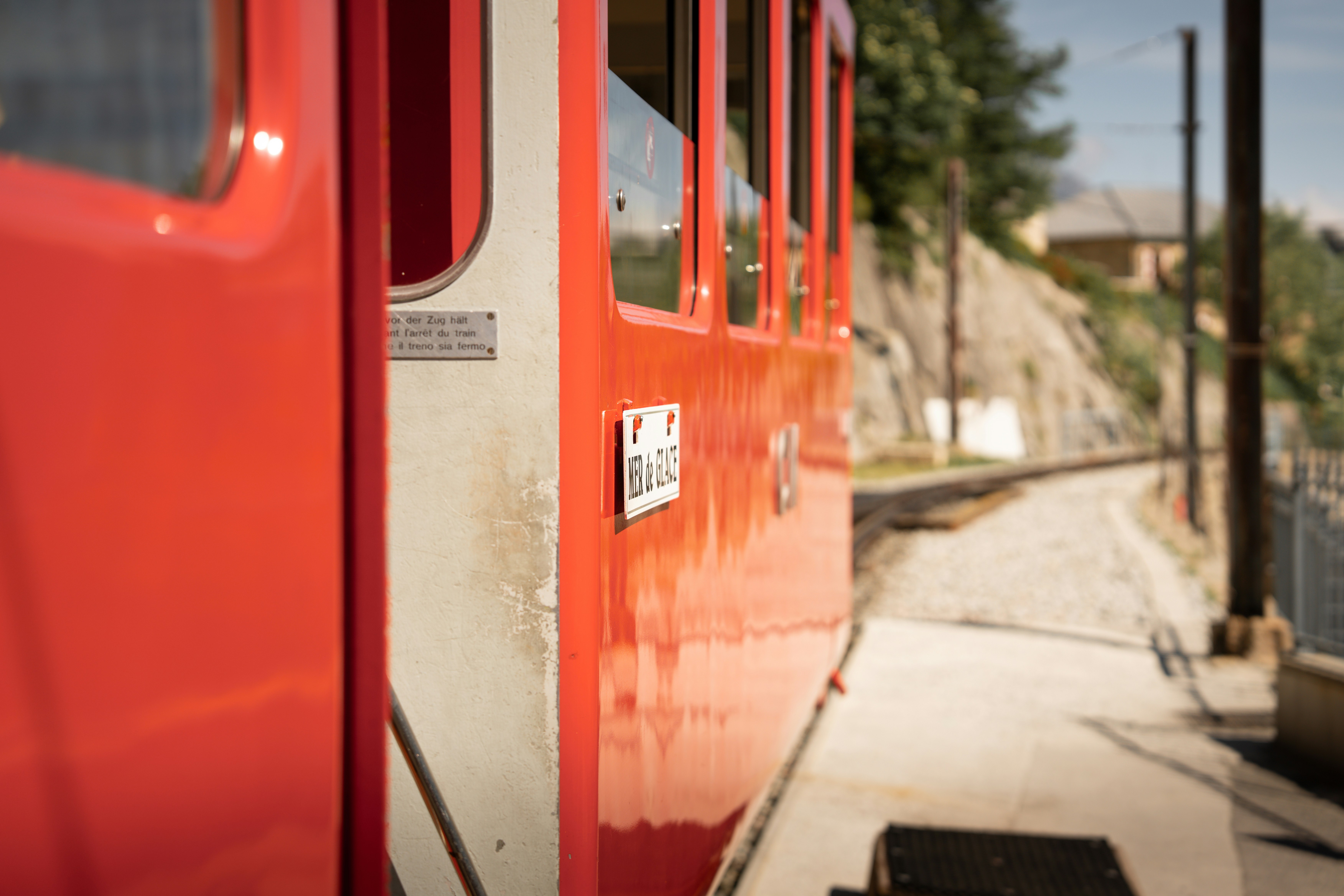 Red train car beside a winding track.