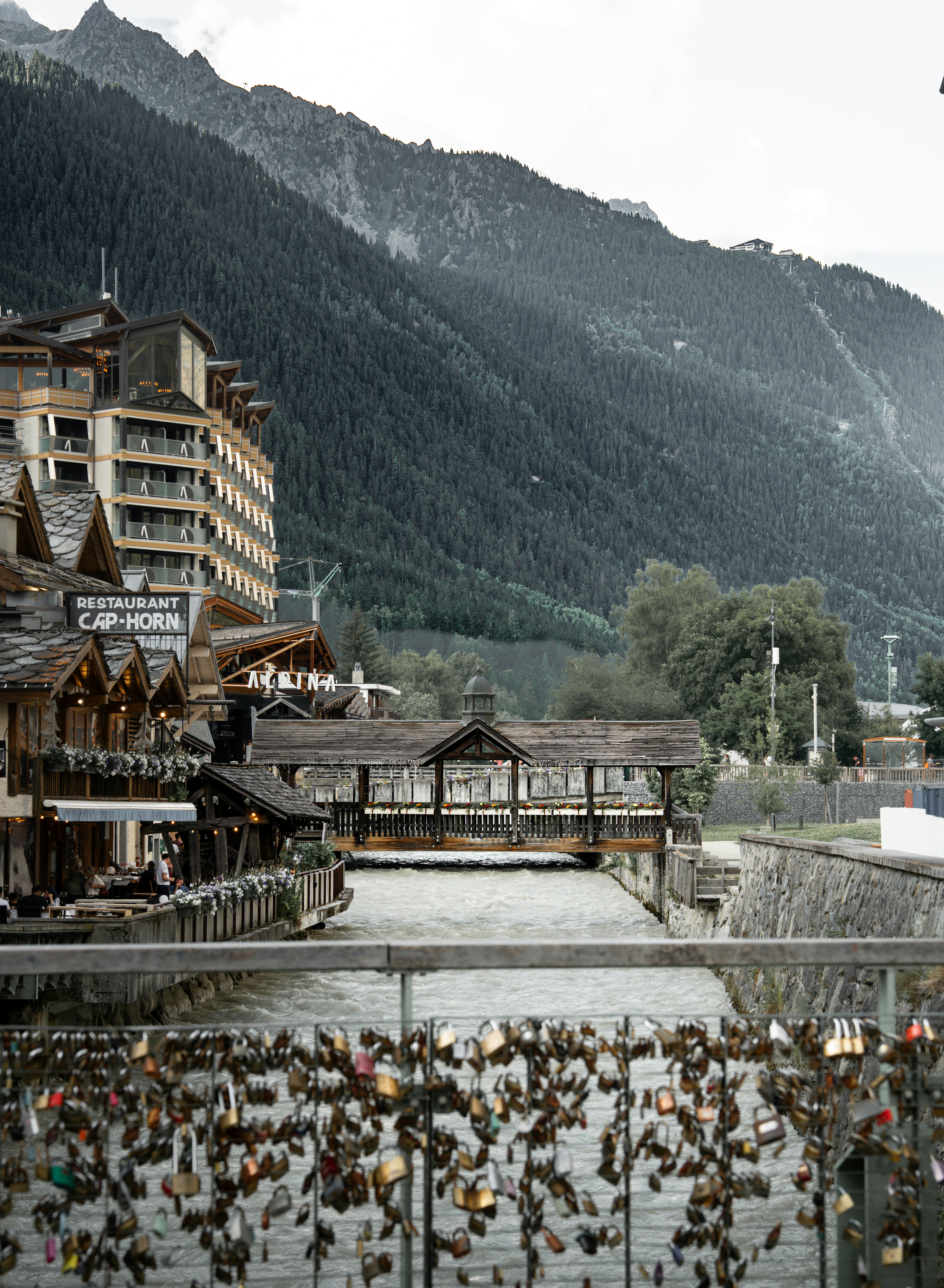 Mountainous town scene with locks on a bridge.