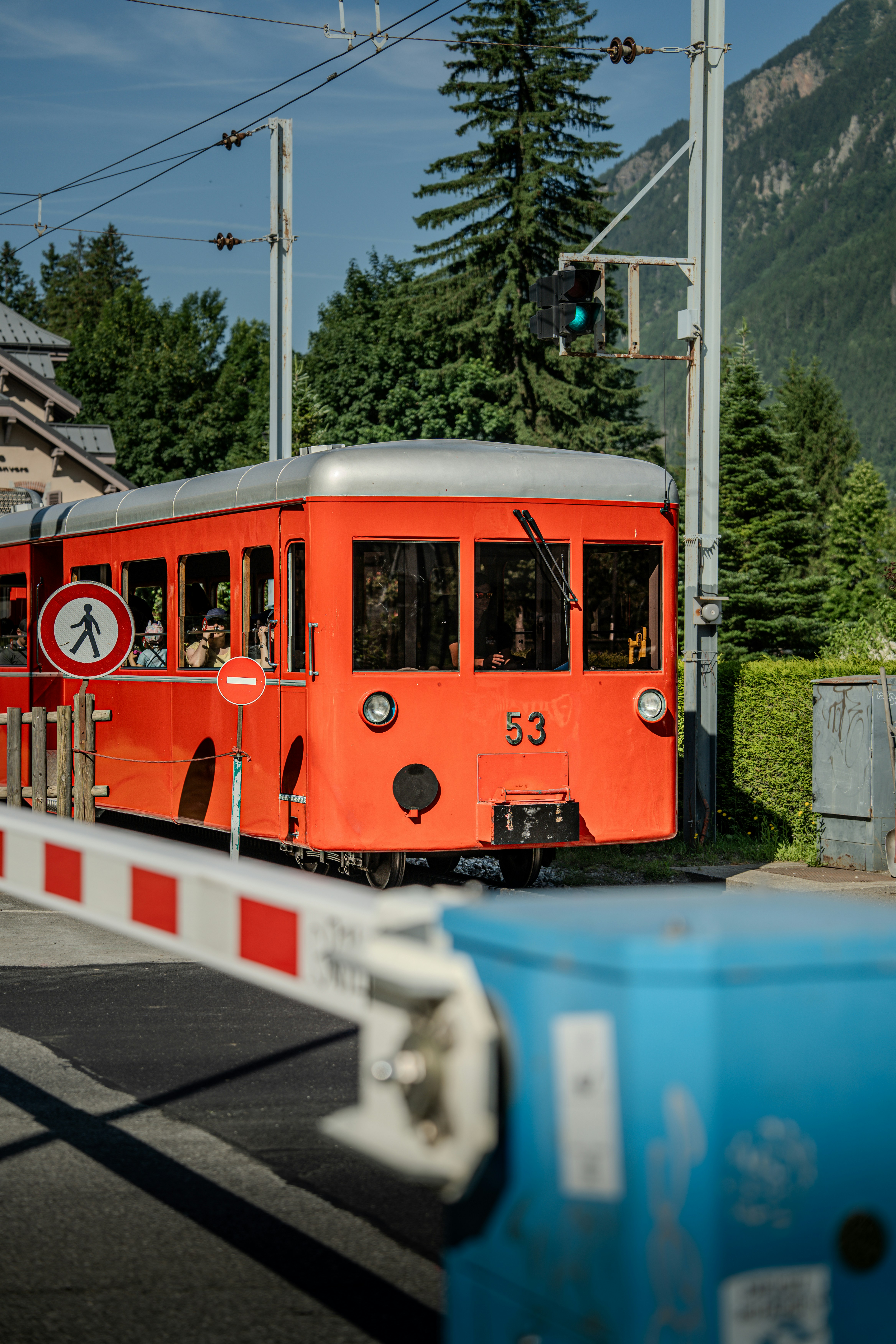 Crimson tram at alpine crossing: a sunlit tableau