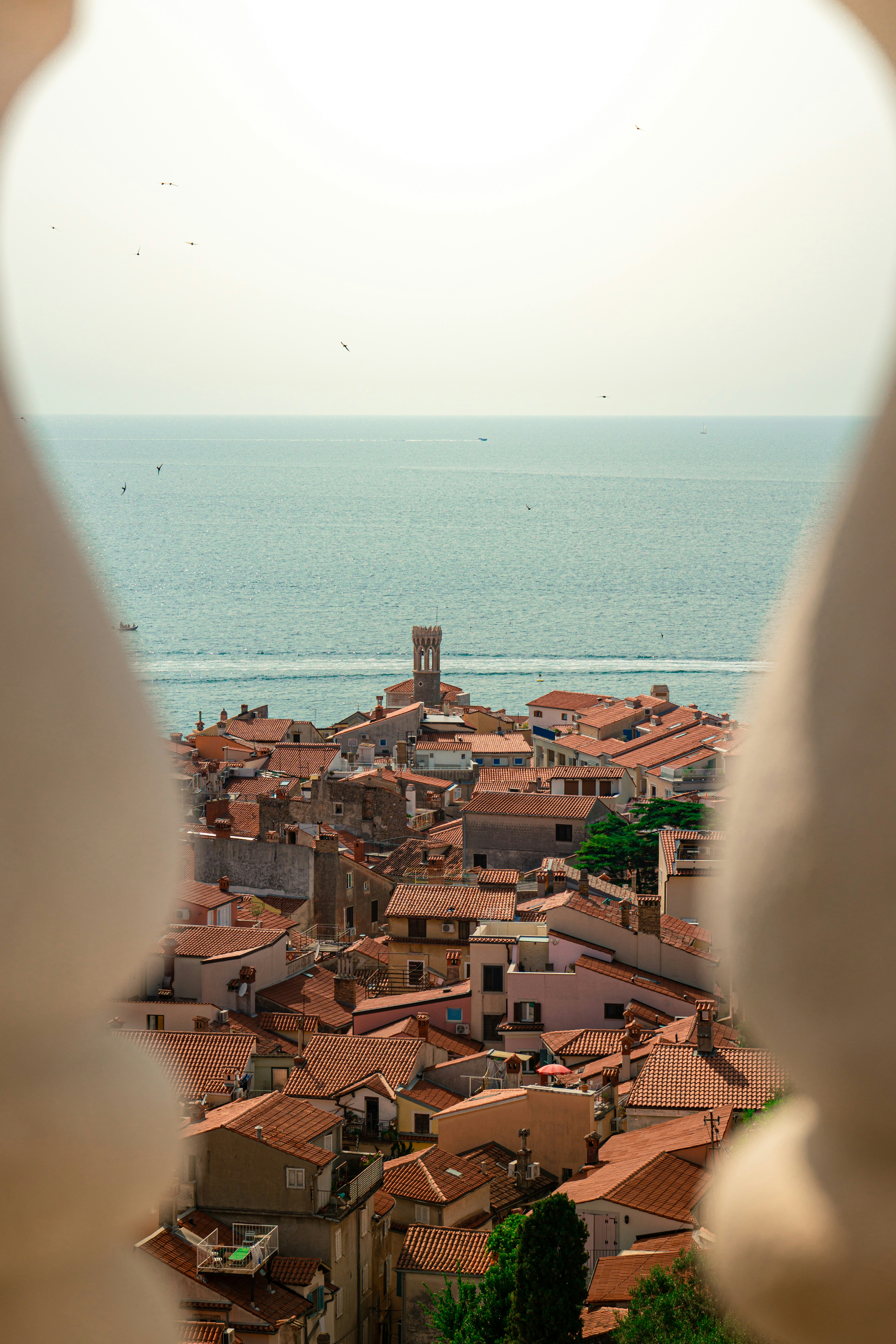 Coastal town framed by courtyard arches watching the sea