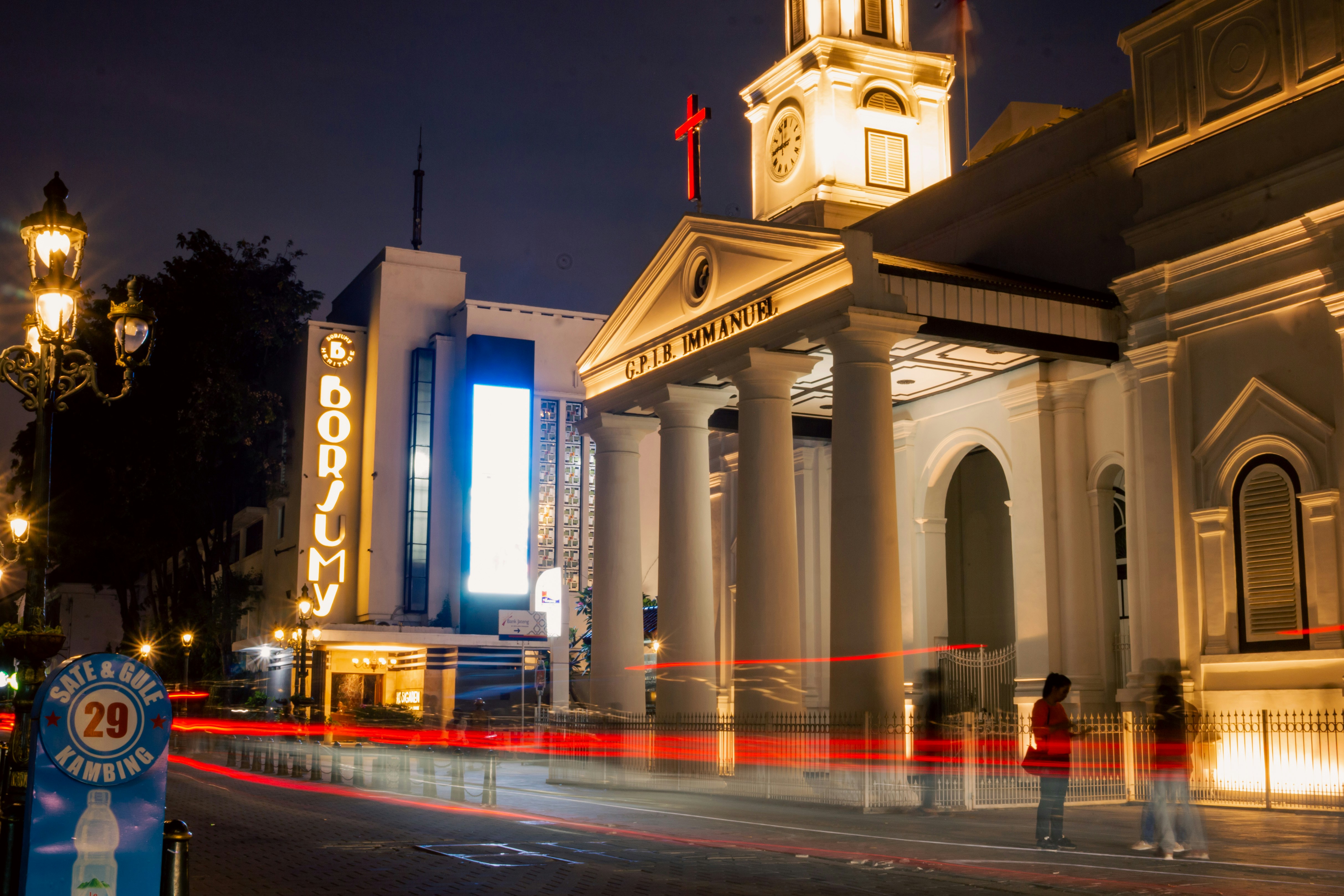 A lit-up building stands at night with light streaks. photo – Free ...