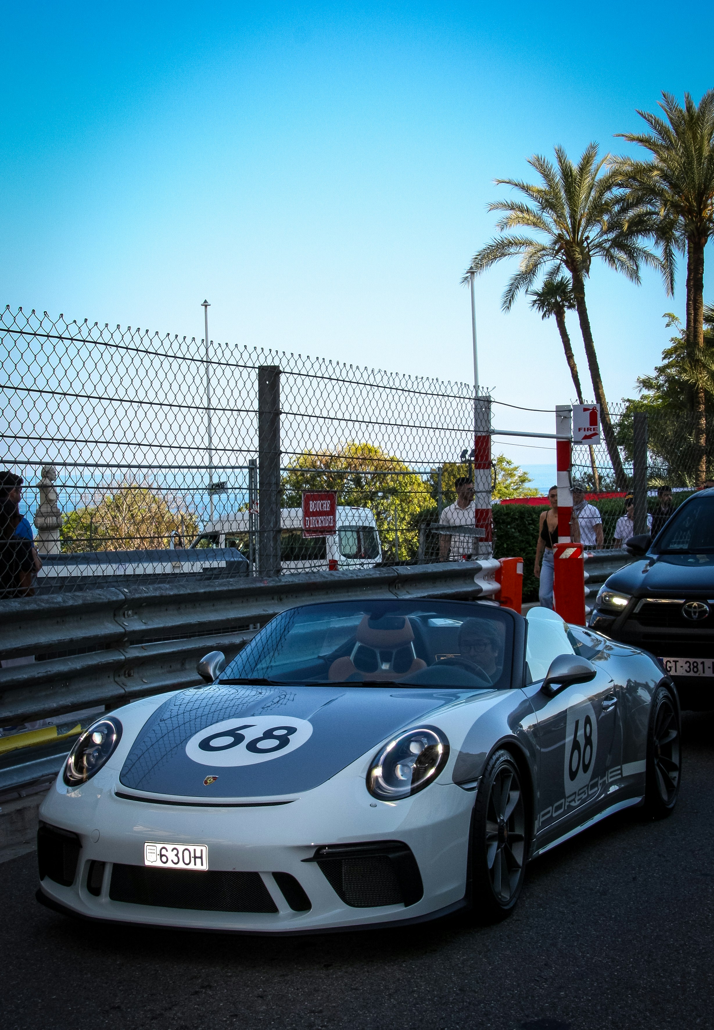 A sleek, classic porsche convertible cruises on a coastal road. photo ...