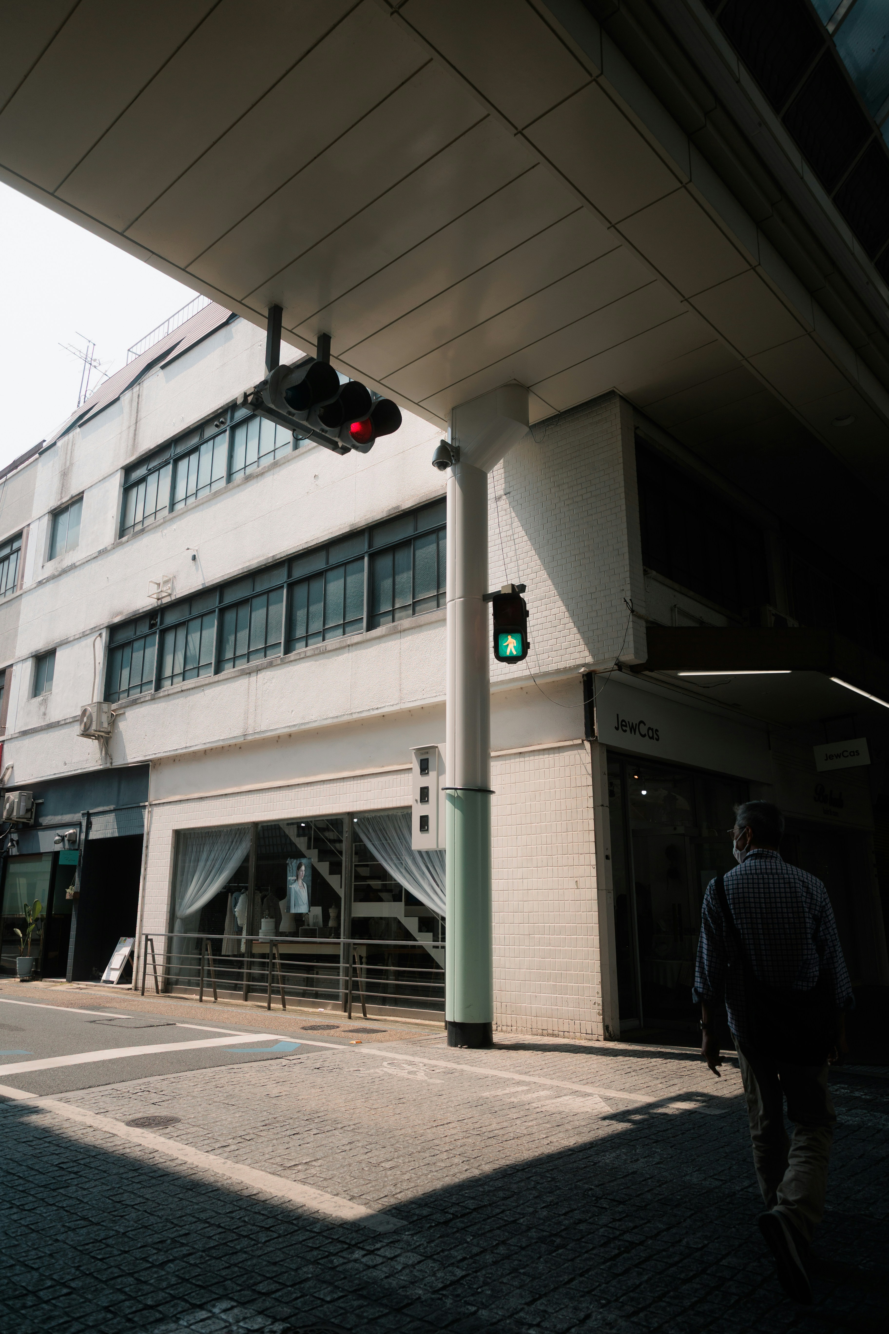 A person walks under a traffic light. photo – Free City Image on Unsplash