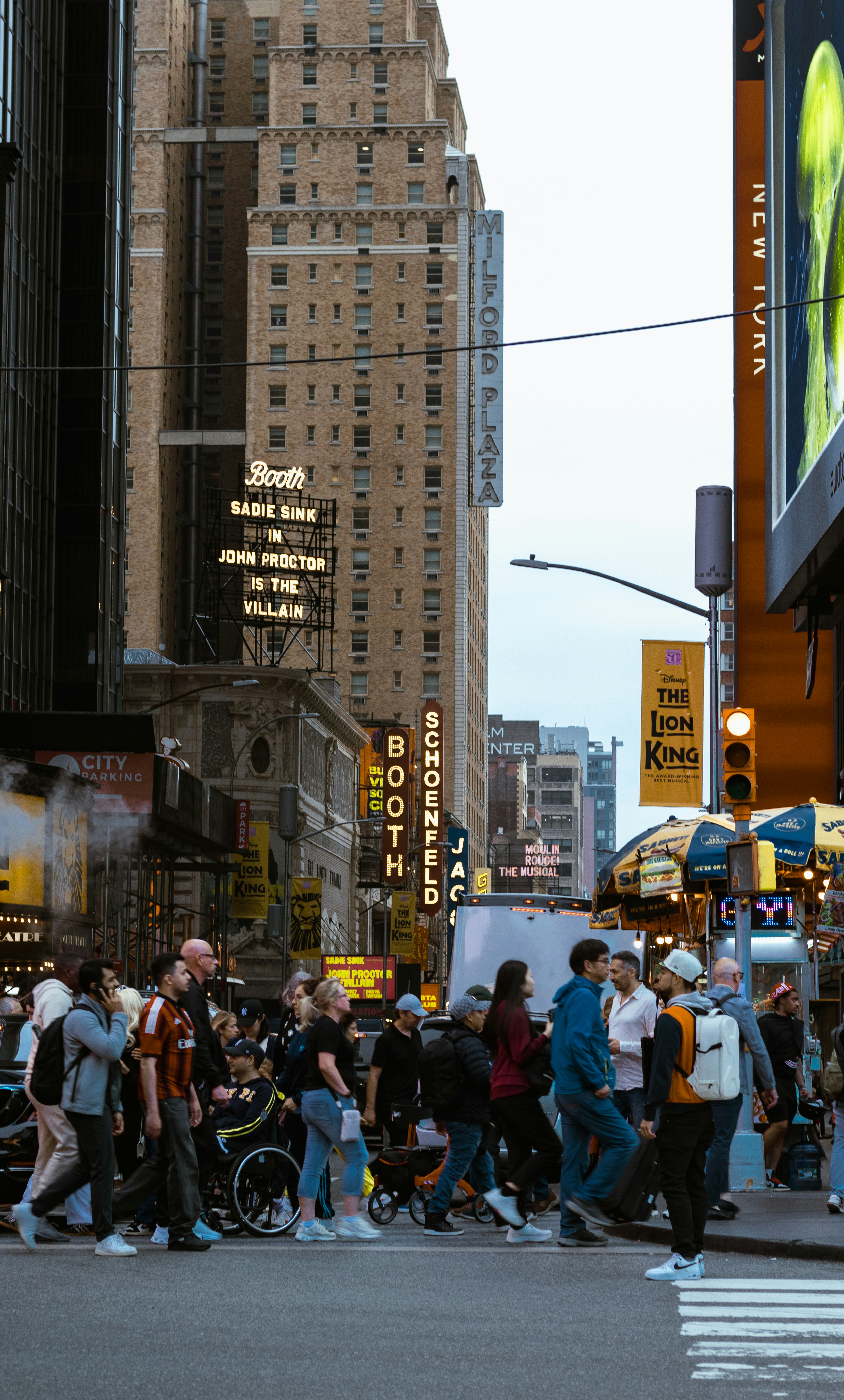 Crosswalk Pulse: City Crowd Beneath Neon Theater