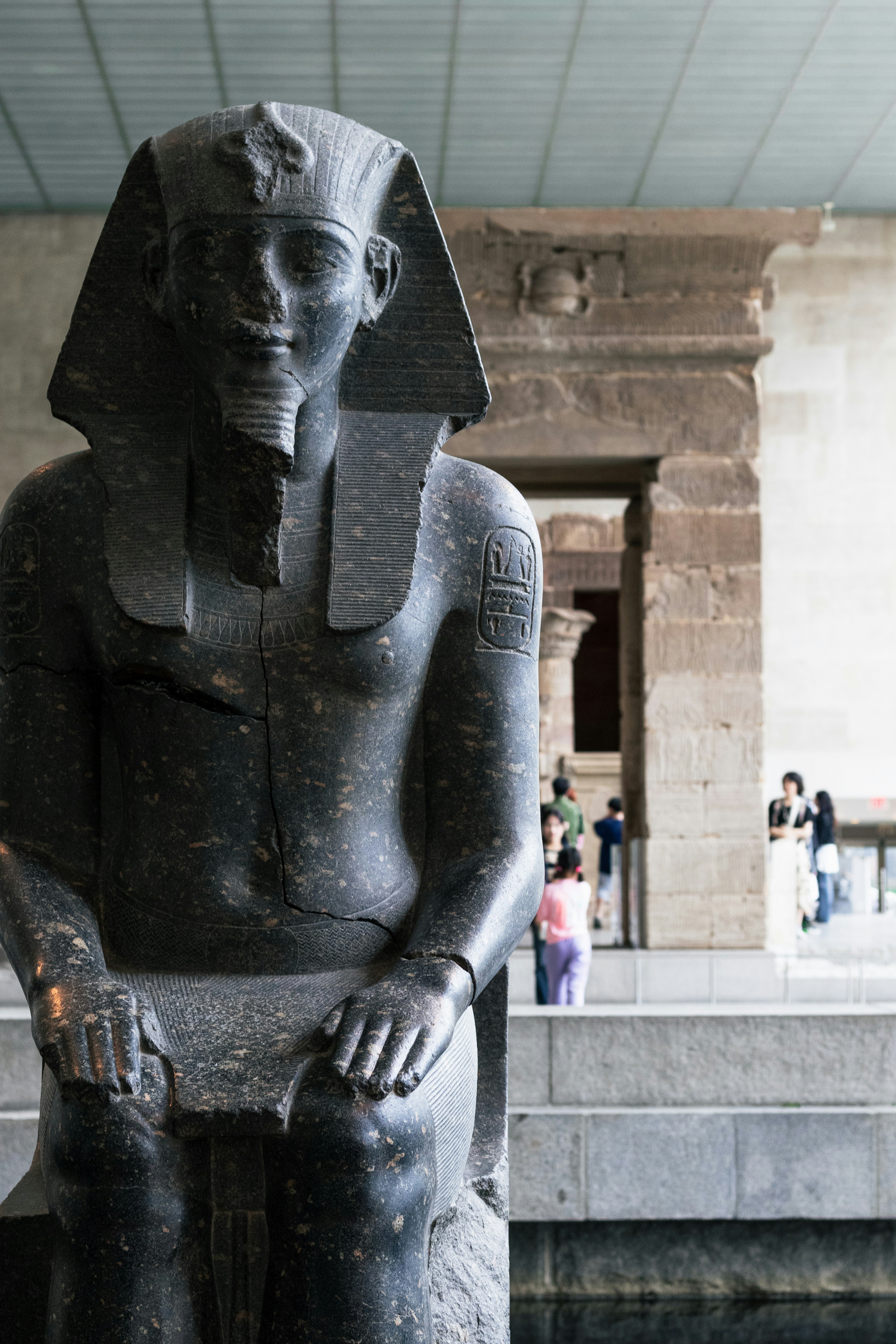 A seated egyptian pharaoh statue is displayed.
