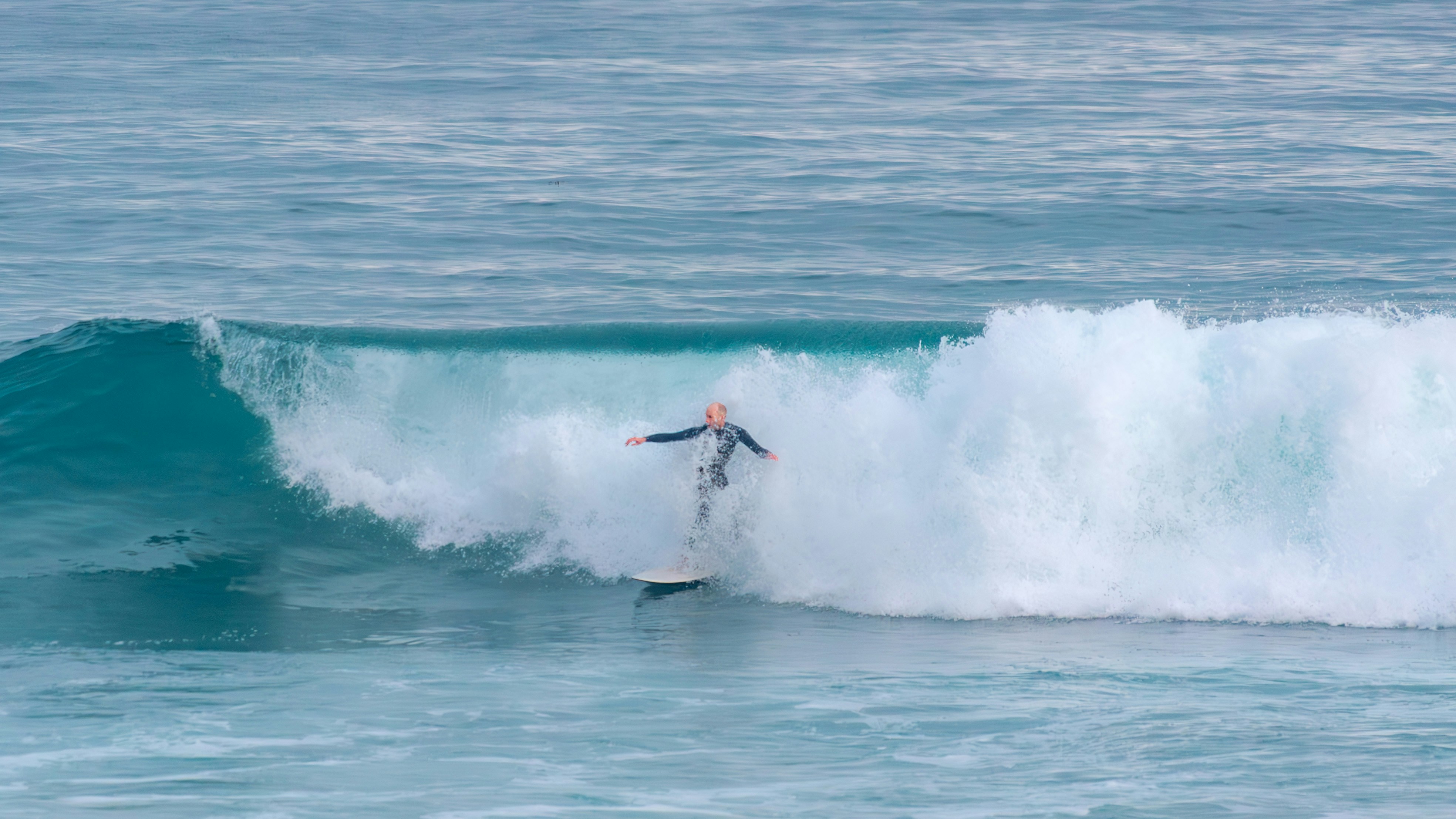 Turning Crest: Surfer Carves a Turquoise Wall