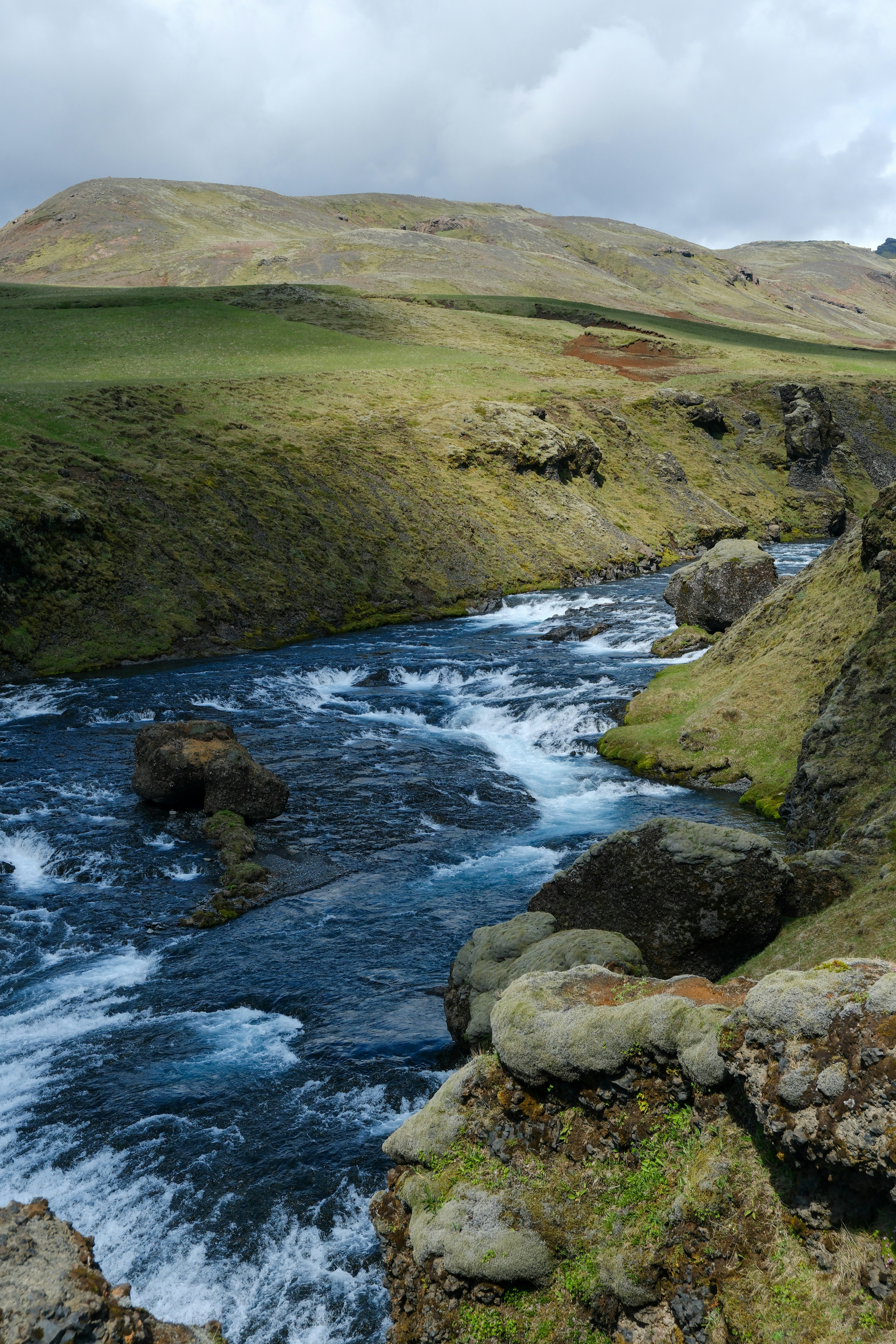 A fast-flowing river cuts through lush green landscape. photo – Free ...