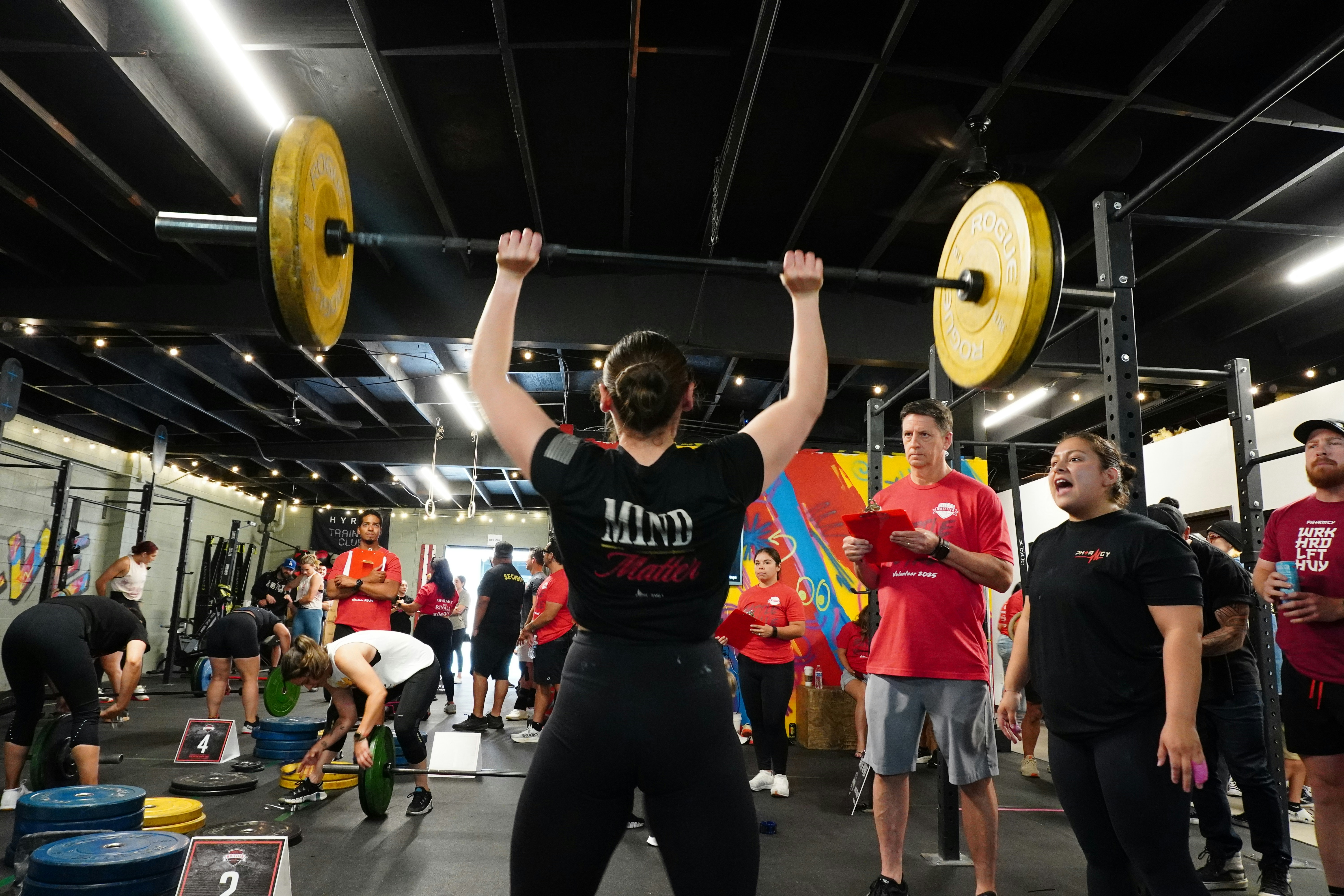A weightlifter completes an overhead lift during competition. photo ...