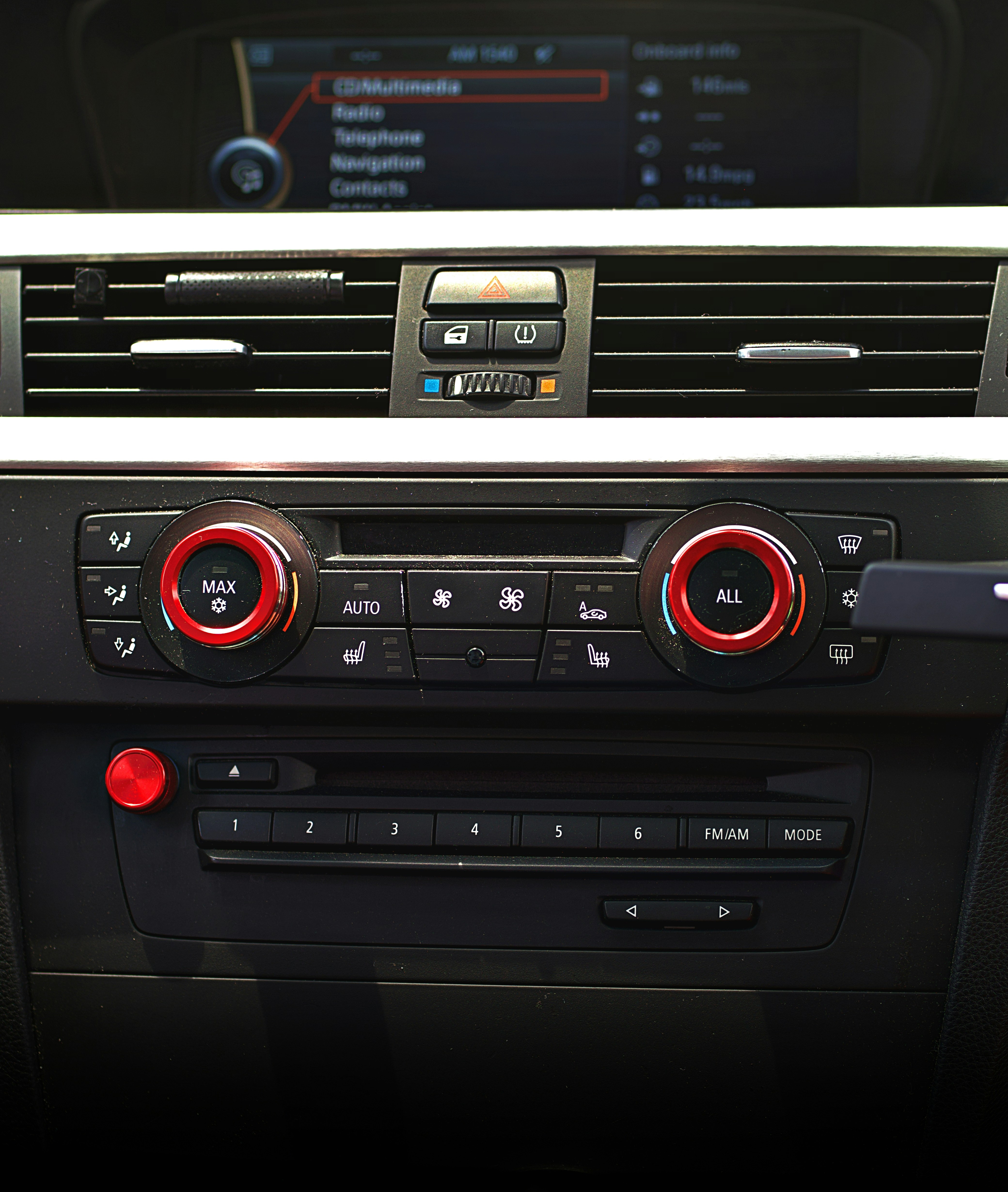 Close-up of a car's dashboard controls, featuring climate settings and multimedia interface for user interaction.