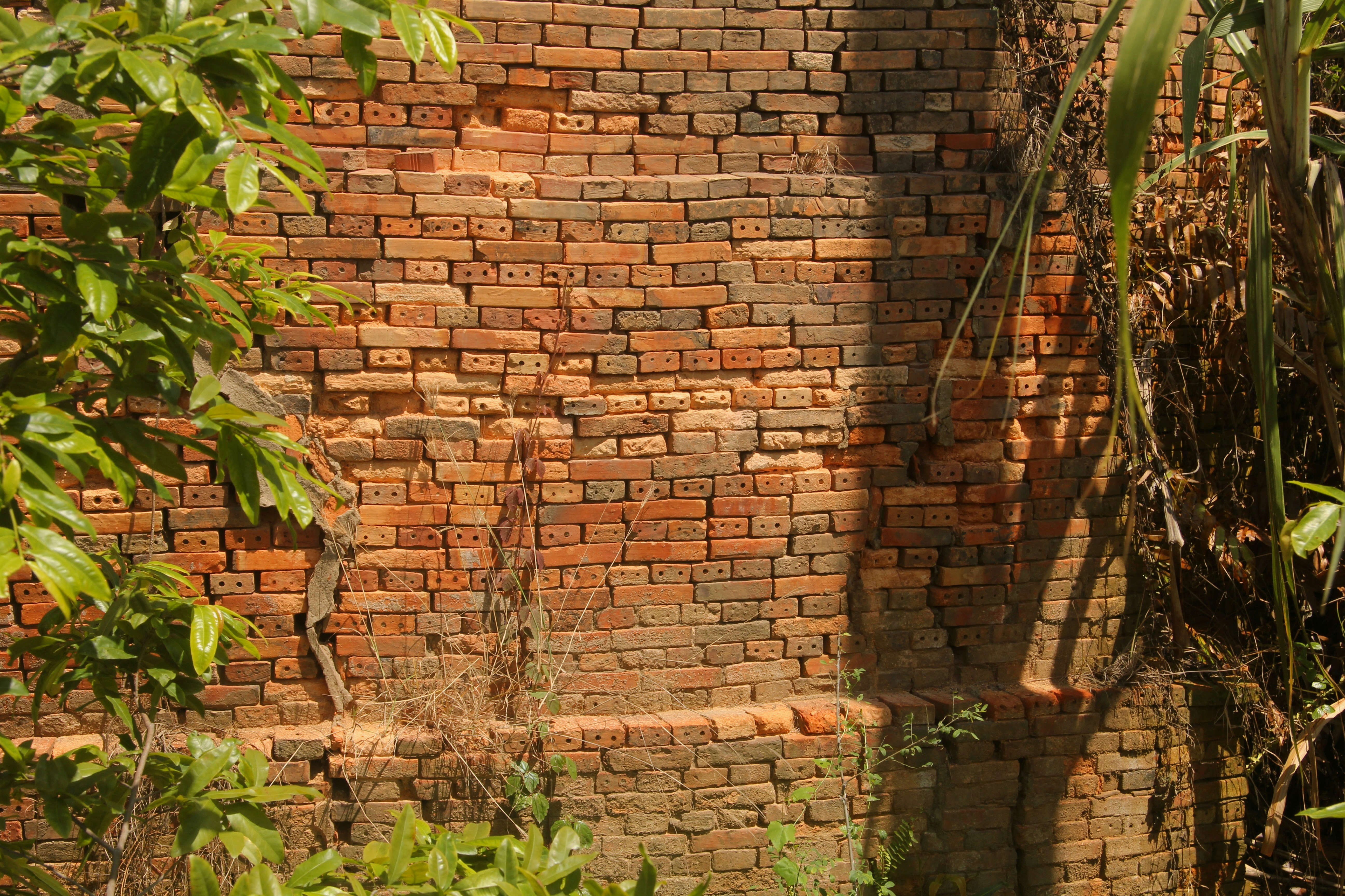 "Mang Thít Brick Kilns – a century-old heritage of red bricks in the heart of Vĩnh Long, where tradition meets nostalgia. This was the place that left the deepest impression on me in June 2025." | An old brick wall is seen, partially obscured.