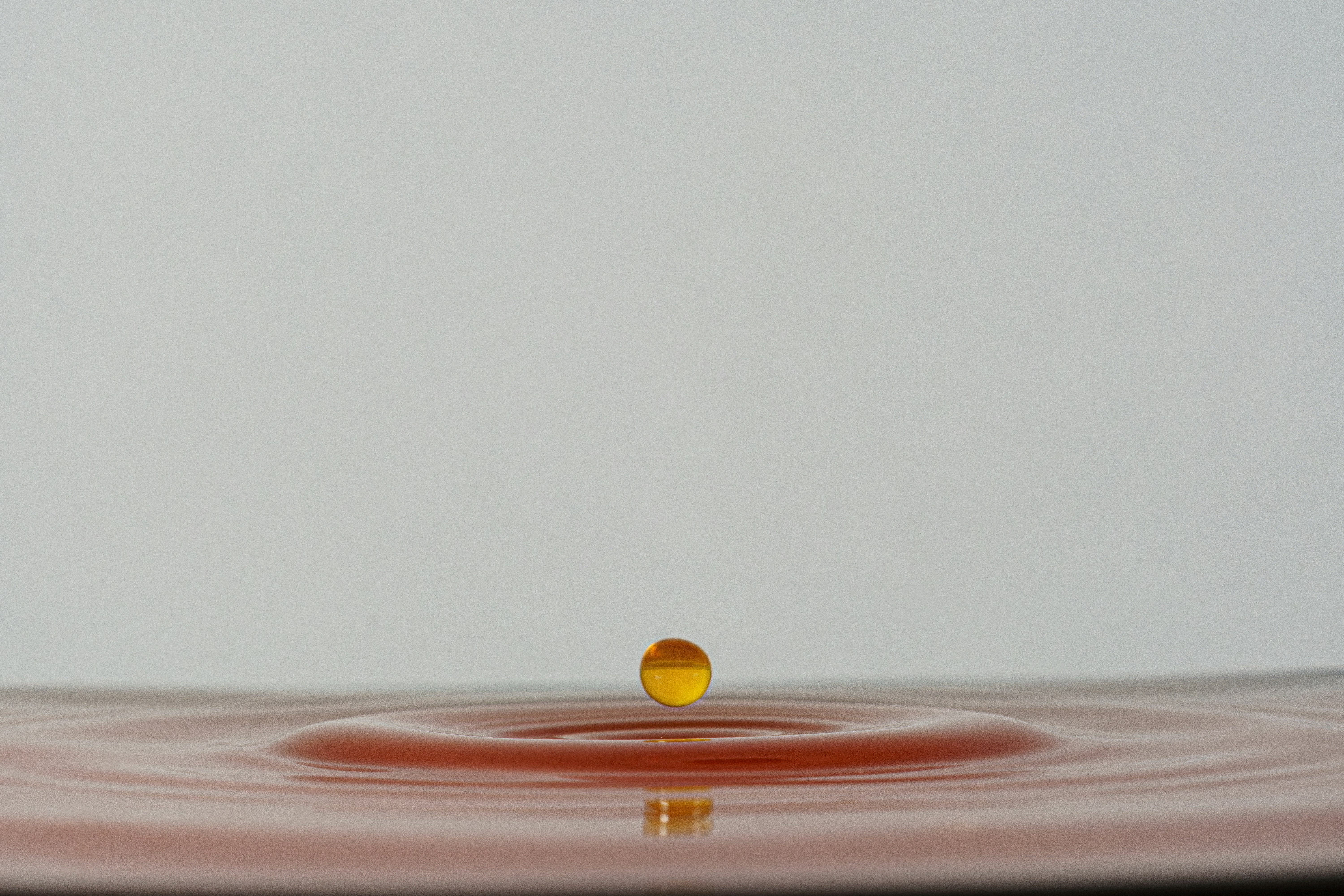 A droplet creates ripples in liquid.
