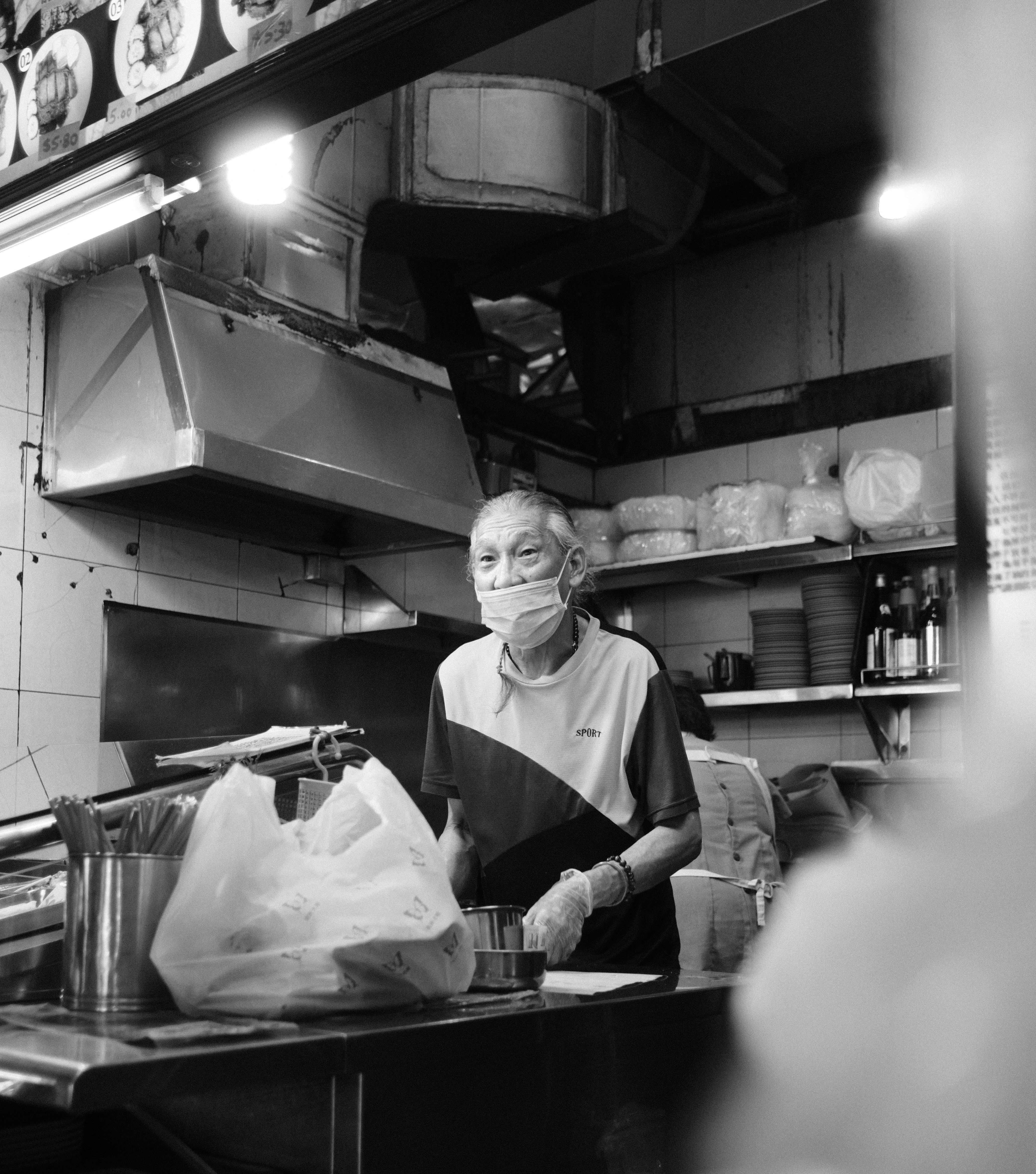 A masked chef prepares food in a bustling kitchen. photo – Free ...