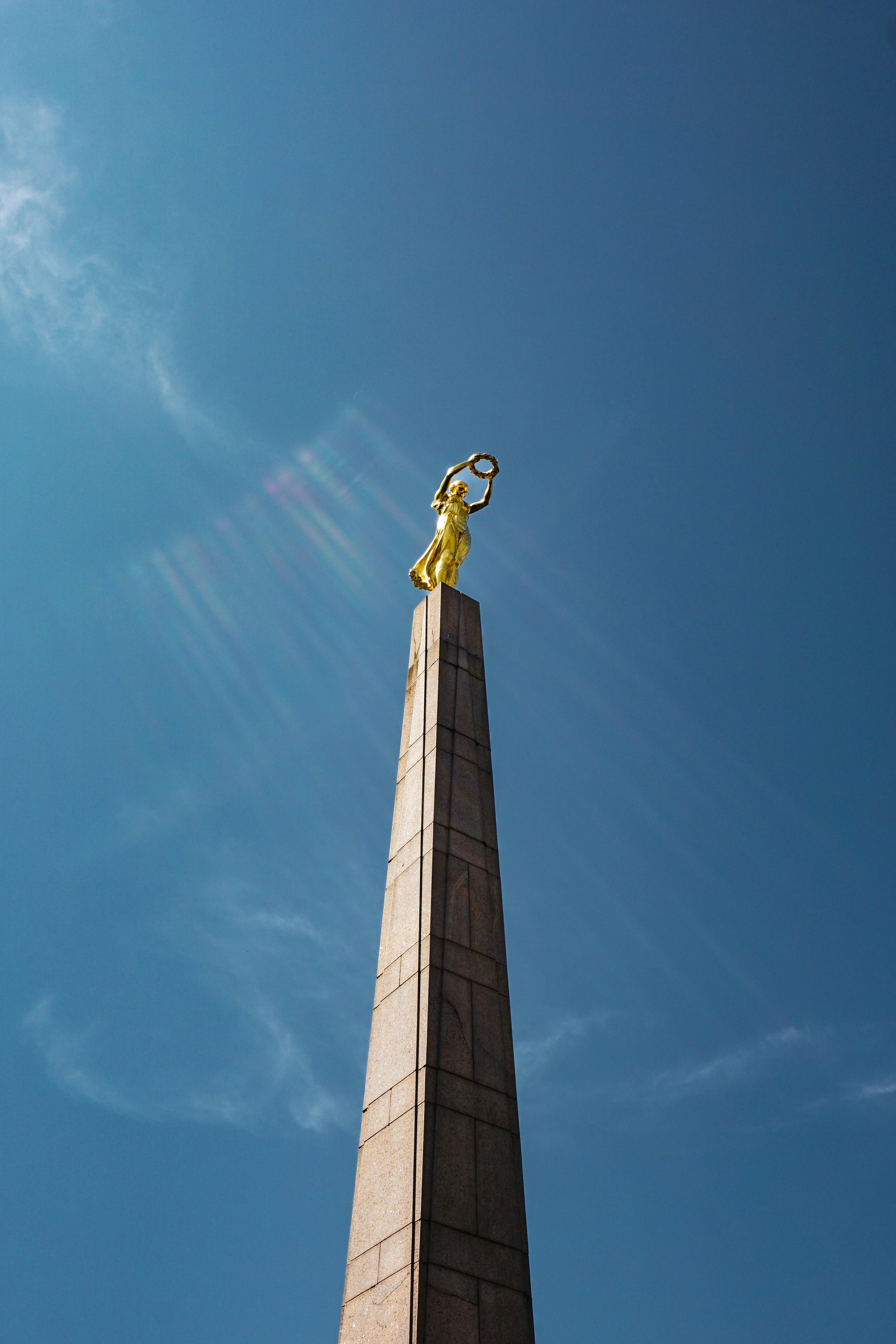 Monument of Remembrance, Luxembourg 🇱🇺 | A golden statue sits atop a tall obelisk.