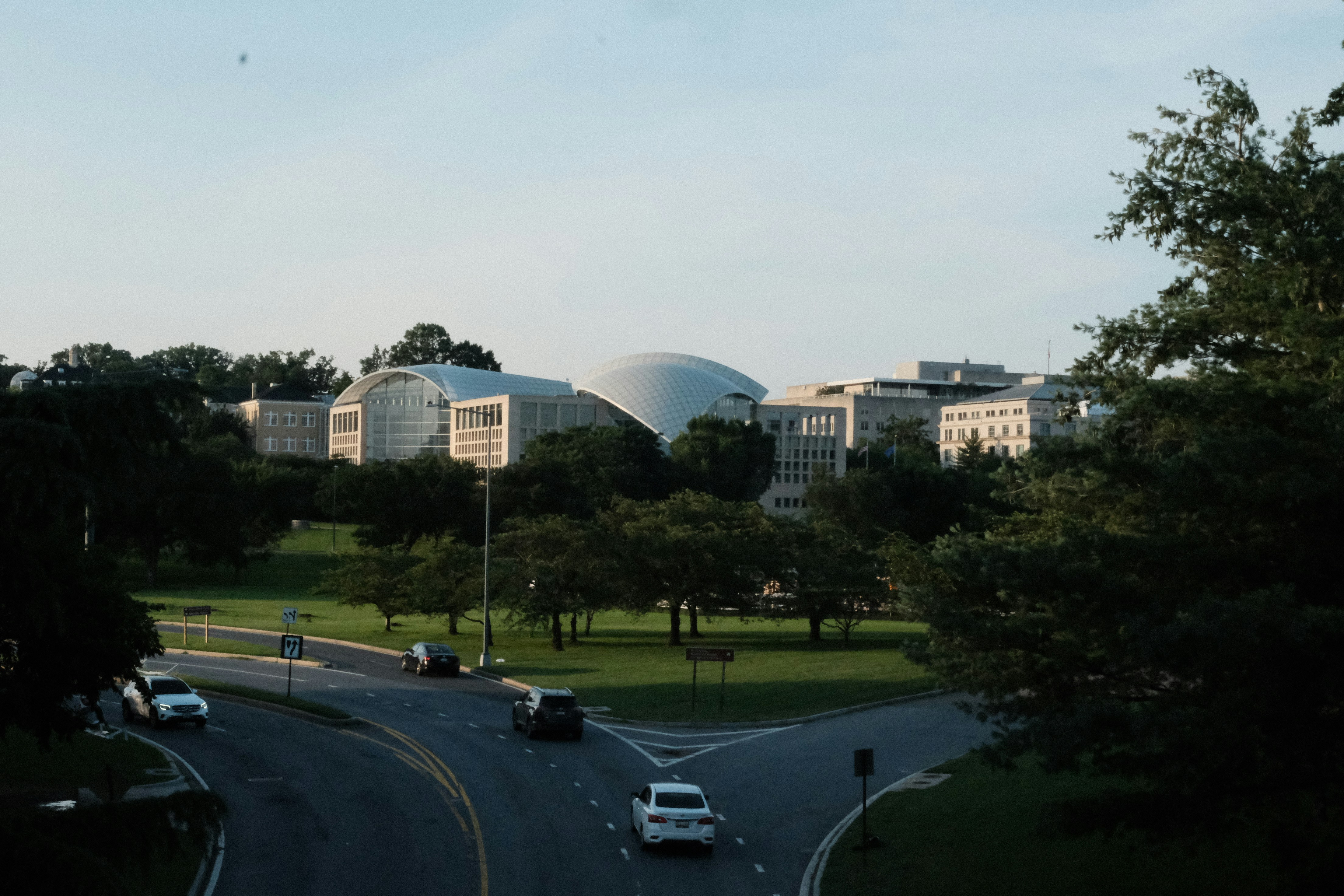 A road curves towards a large, modern building.