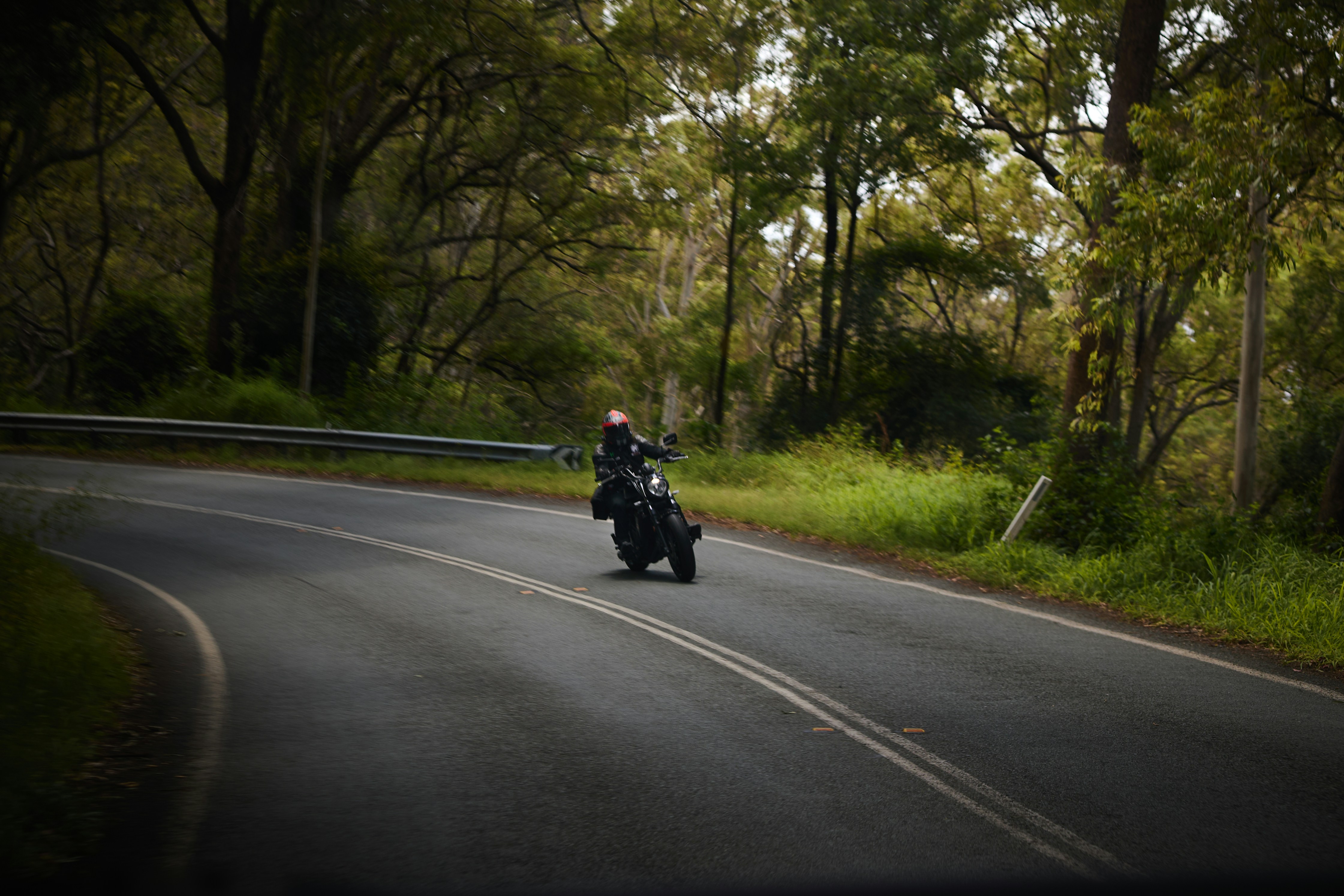 A motorcycle rider curves around a road. photo – Free Road Image on ...