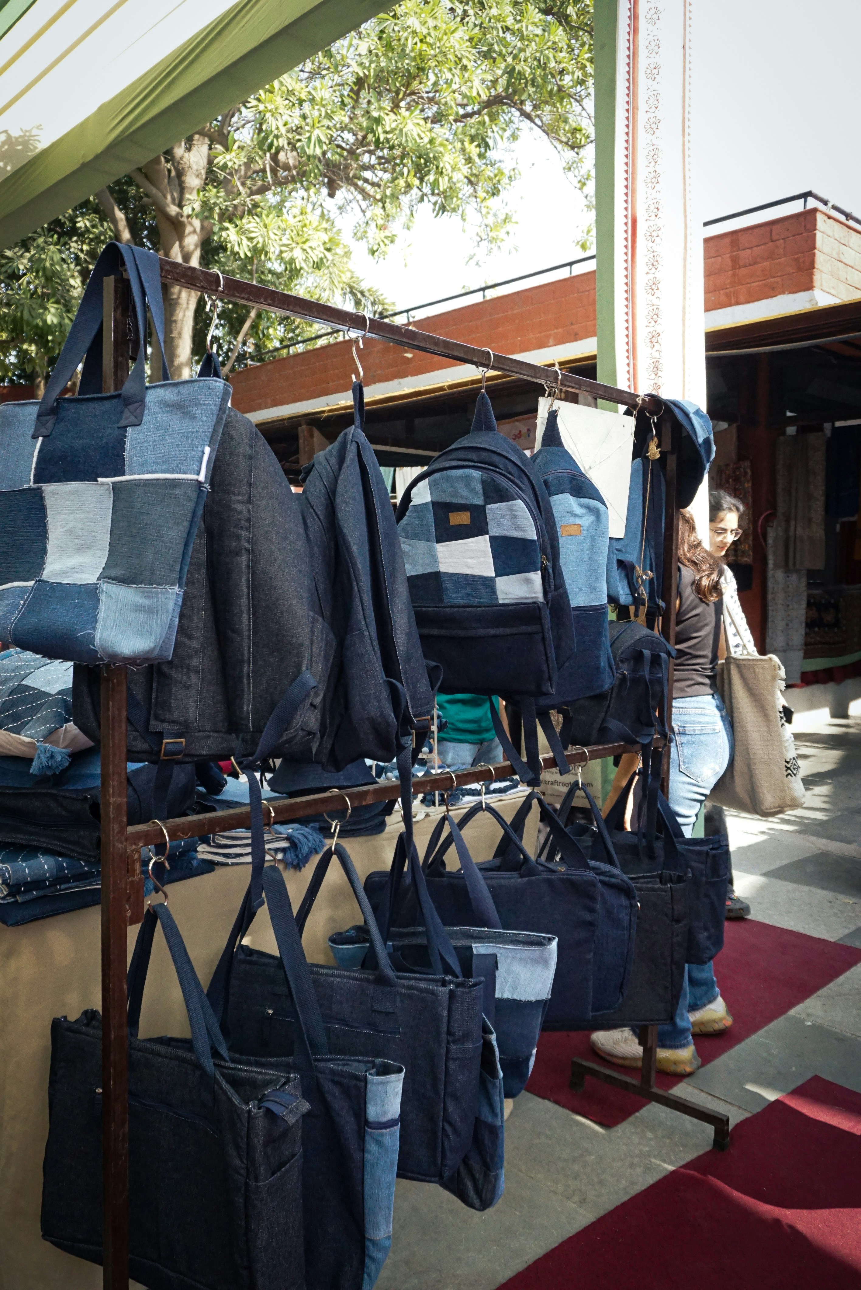 Jeans bags are displayed at an outdoor market.