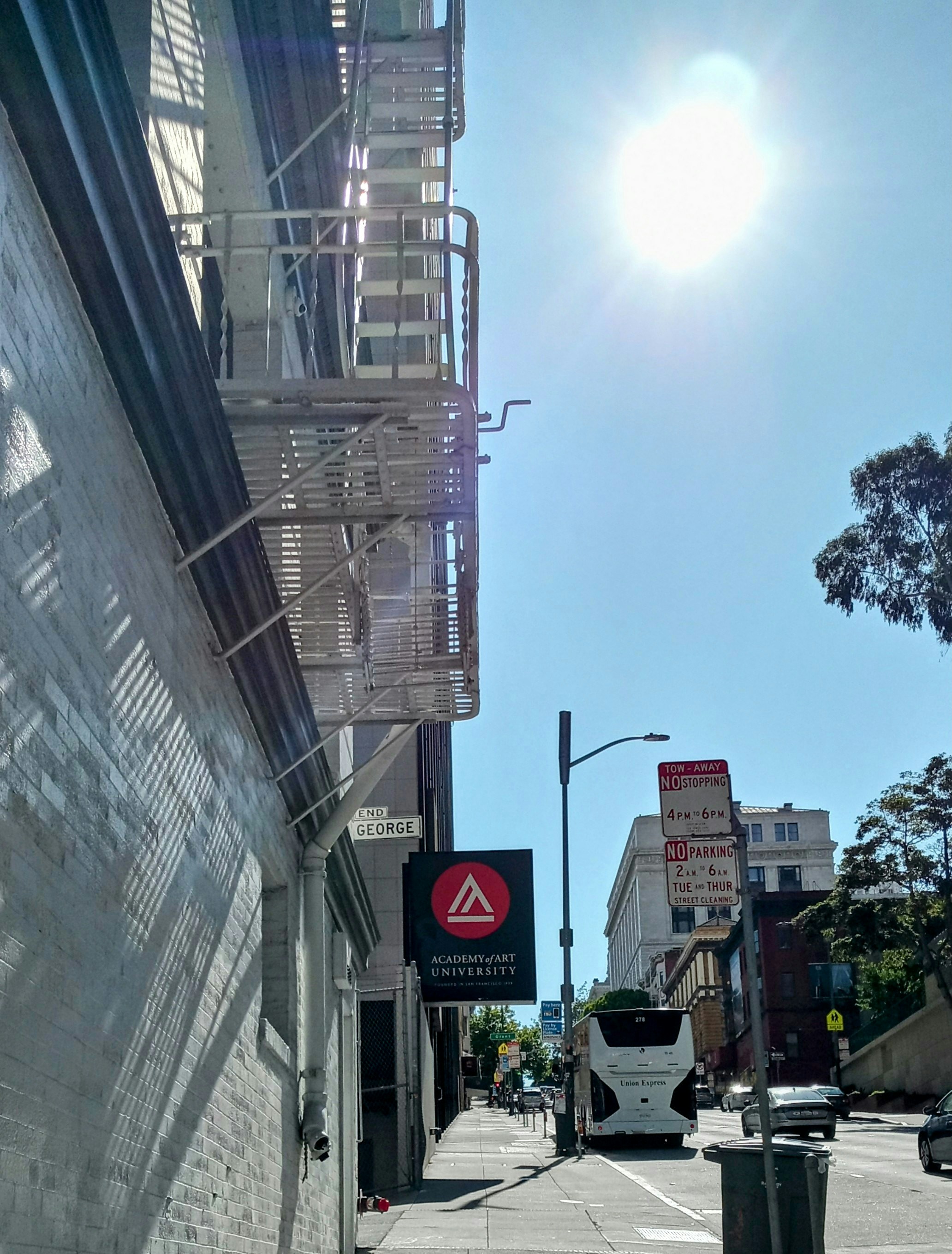 A sunny street with buildings and signs.