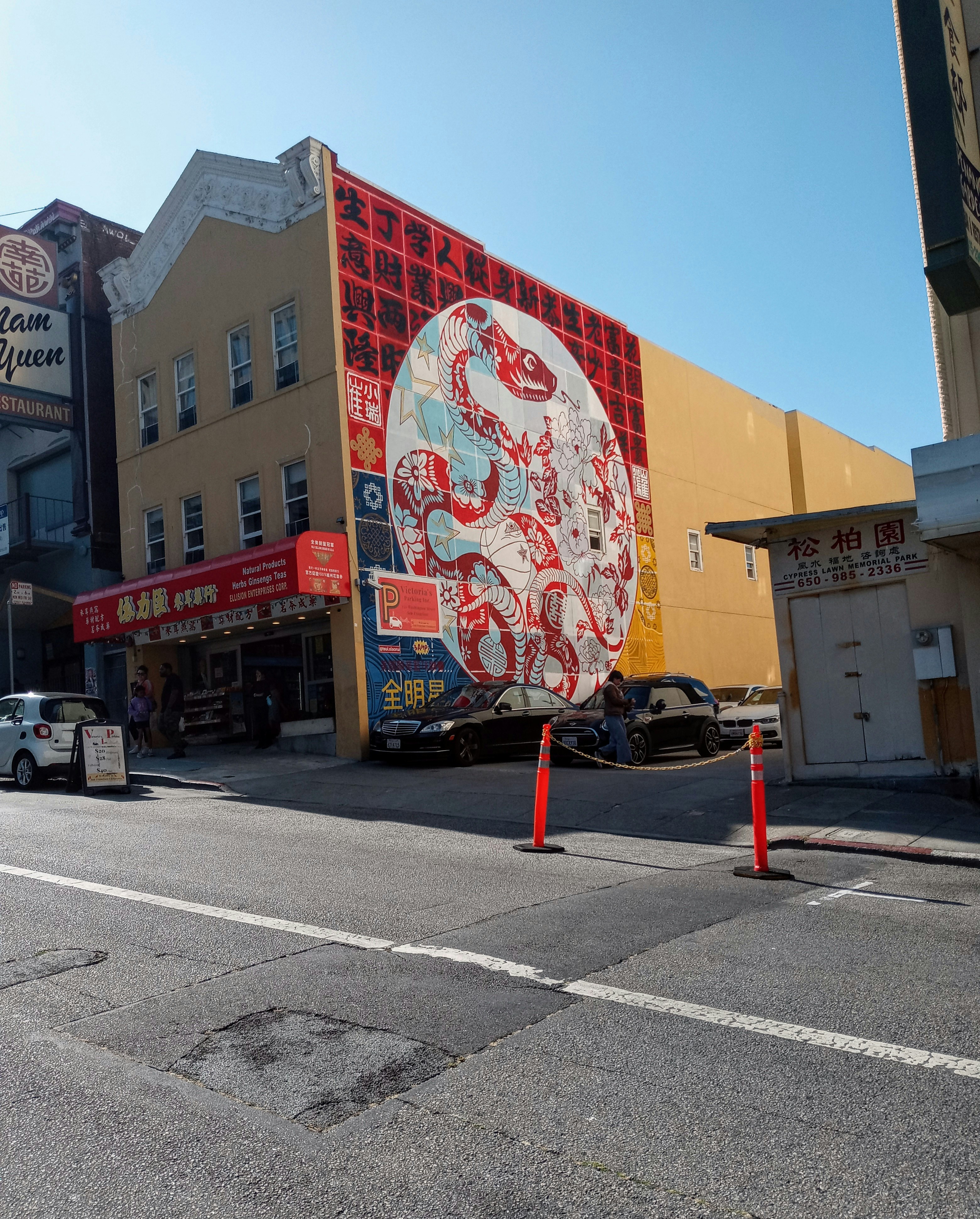 Circle of Color: Red-White Dragon Mural Anchoring a Sunlit Street