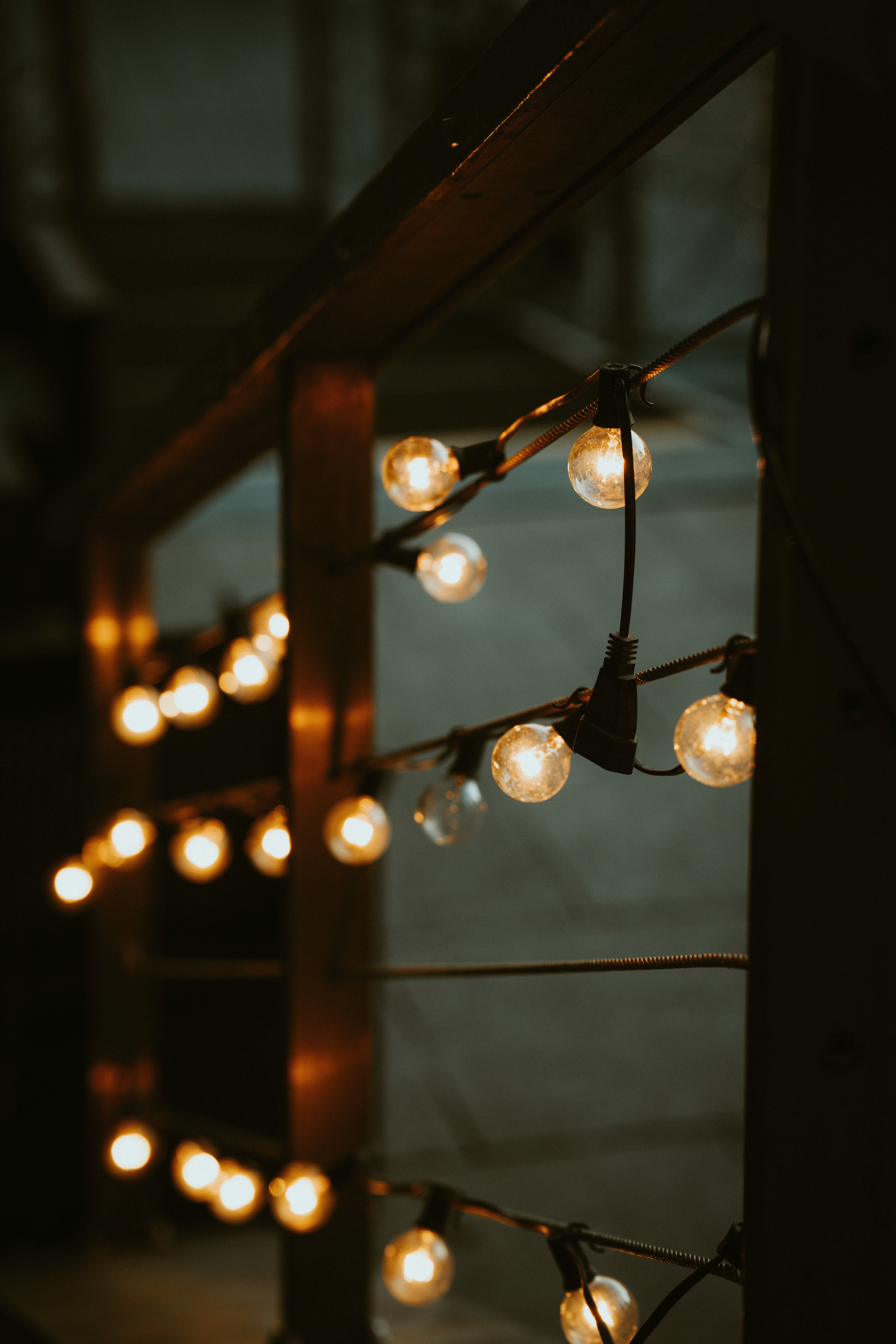 String lights illuminate a wooden railing.