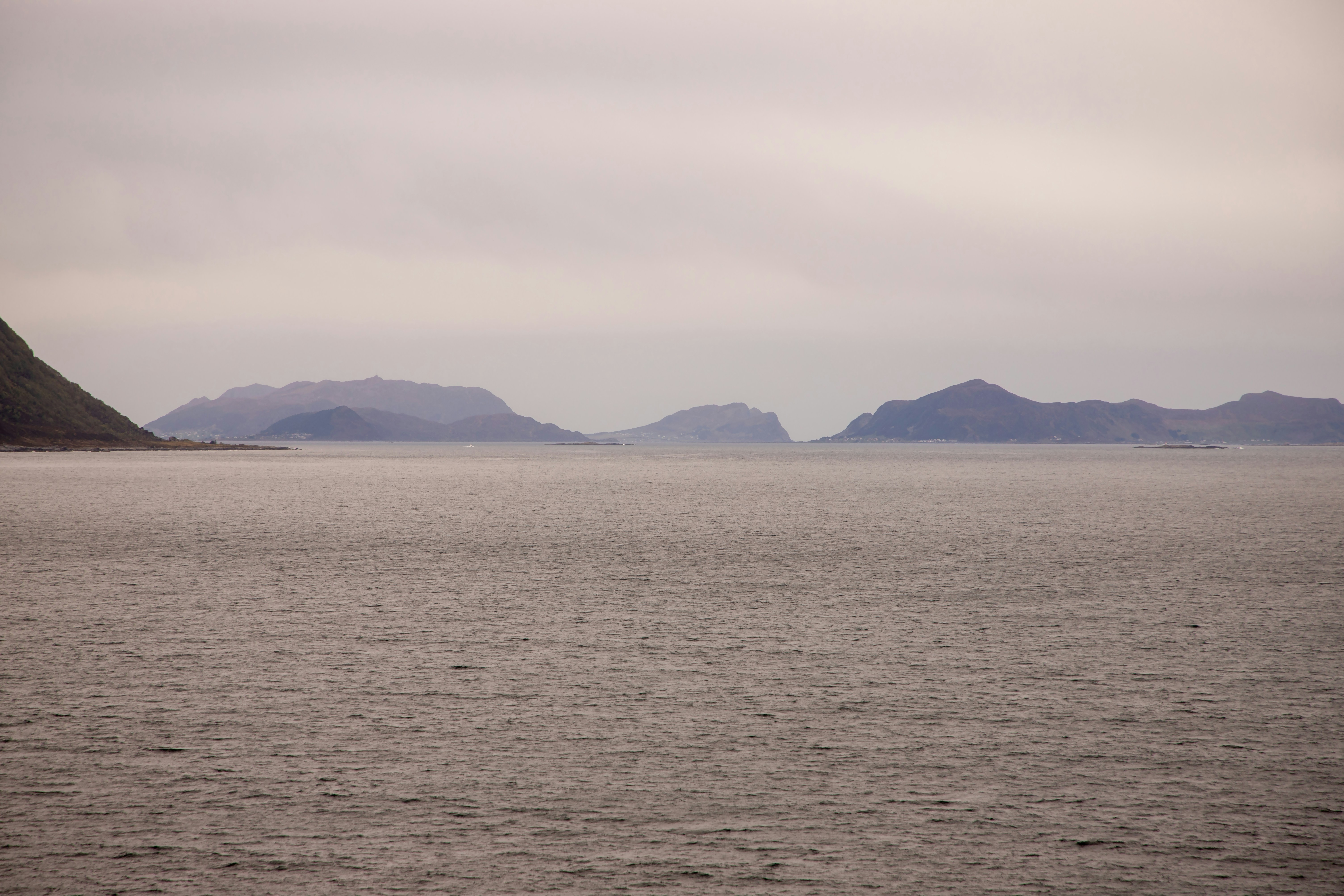 A vast sea stretches towards distant mountains.