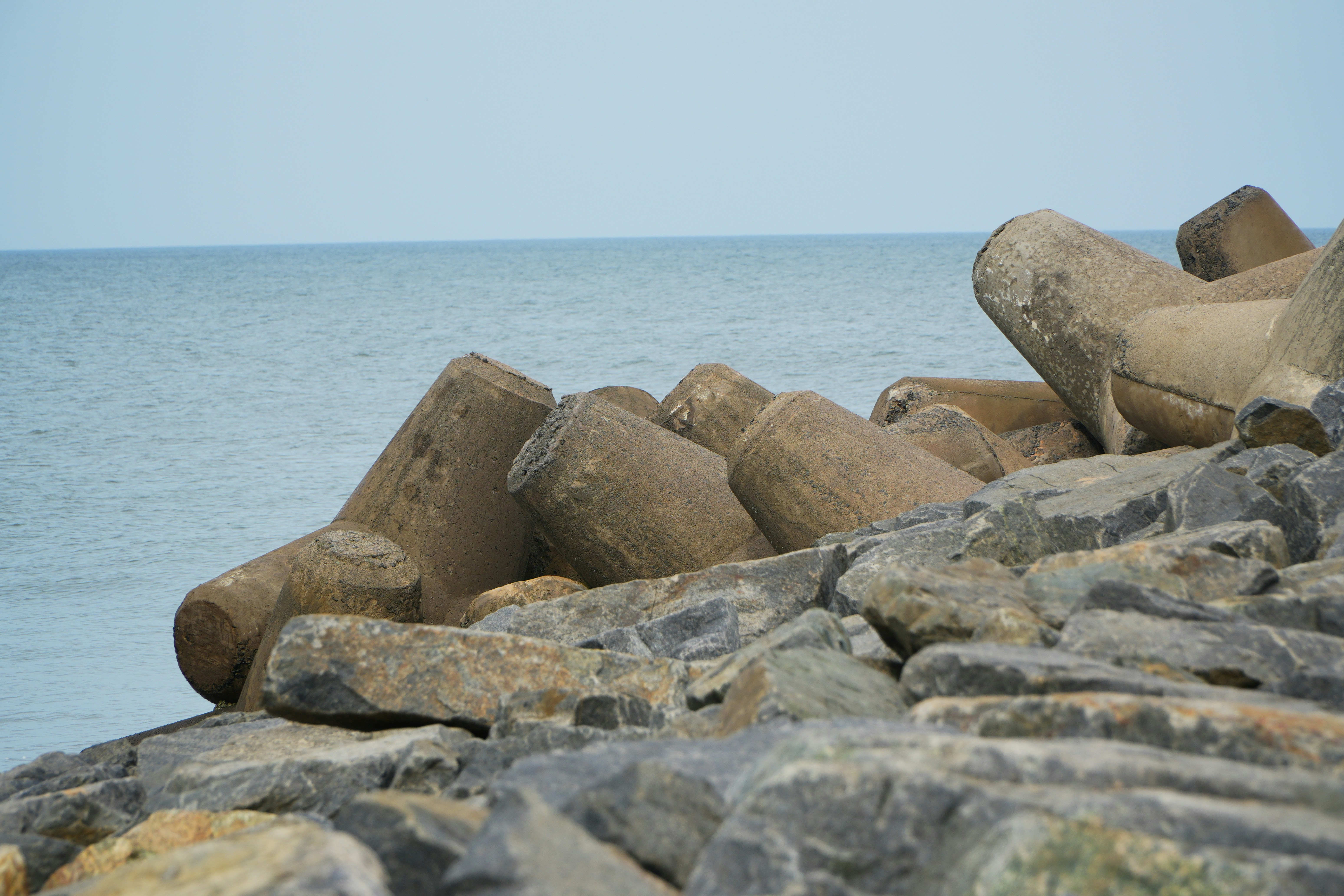 Stone Giants Guard the Seaside: A Quiet Breakwater in Calm Light