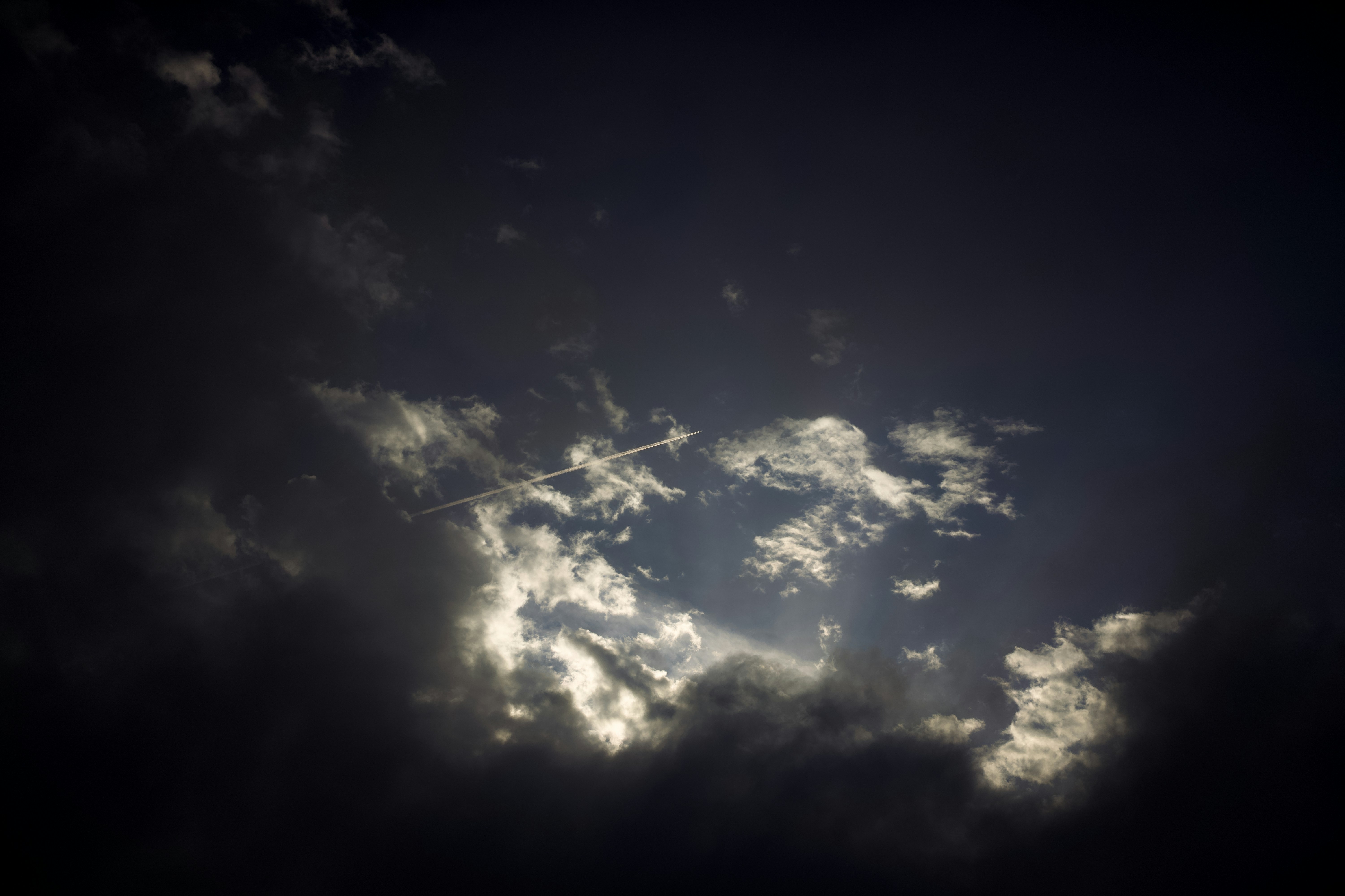 Sunlight peeks through dark, ominous clouds.