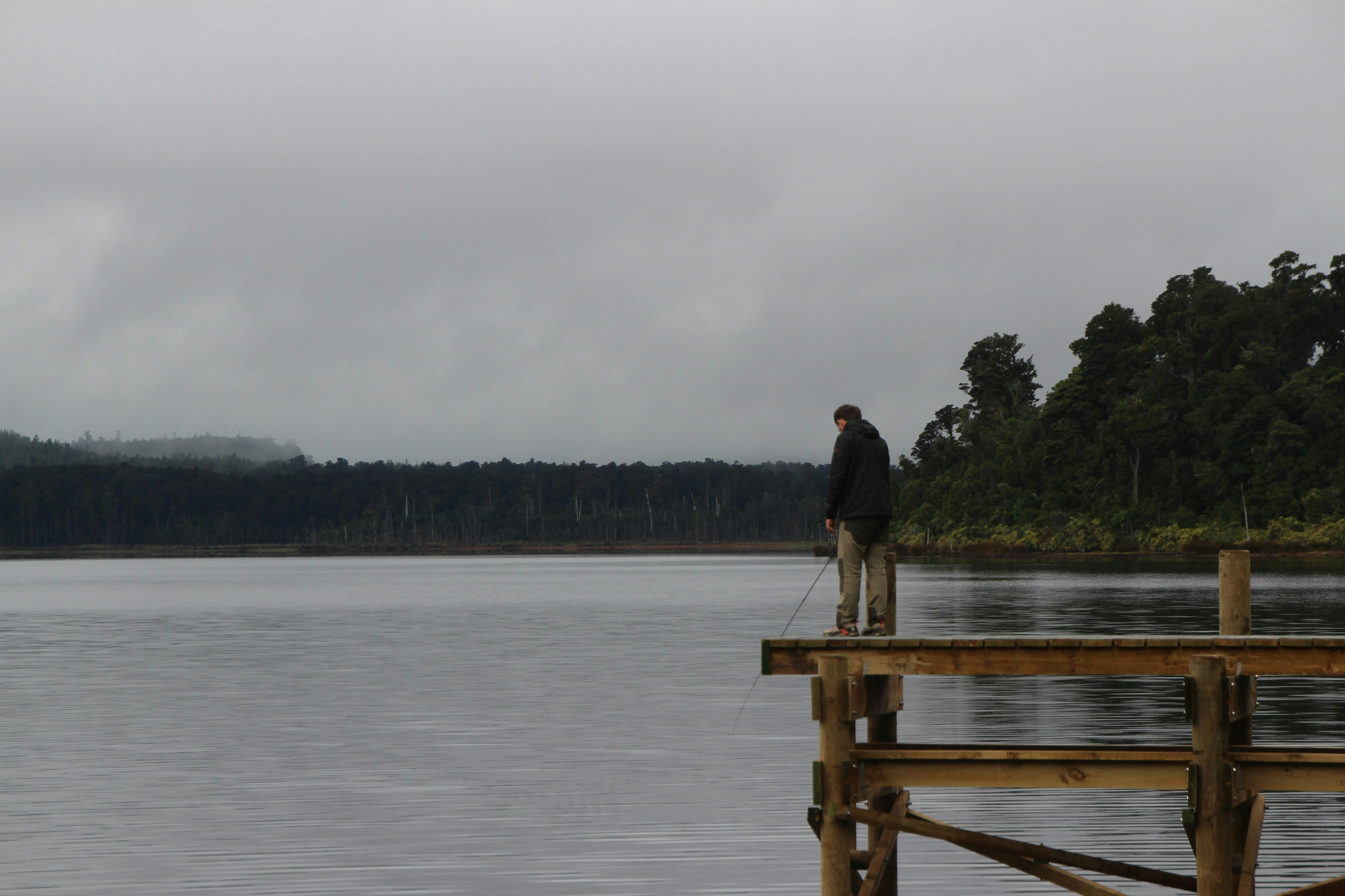 A person stands at the edge of the lake.