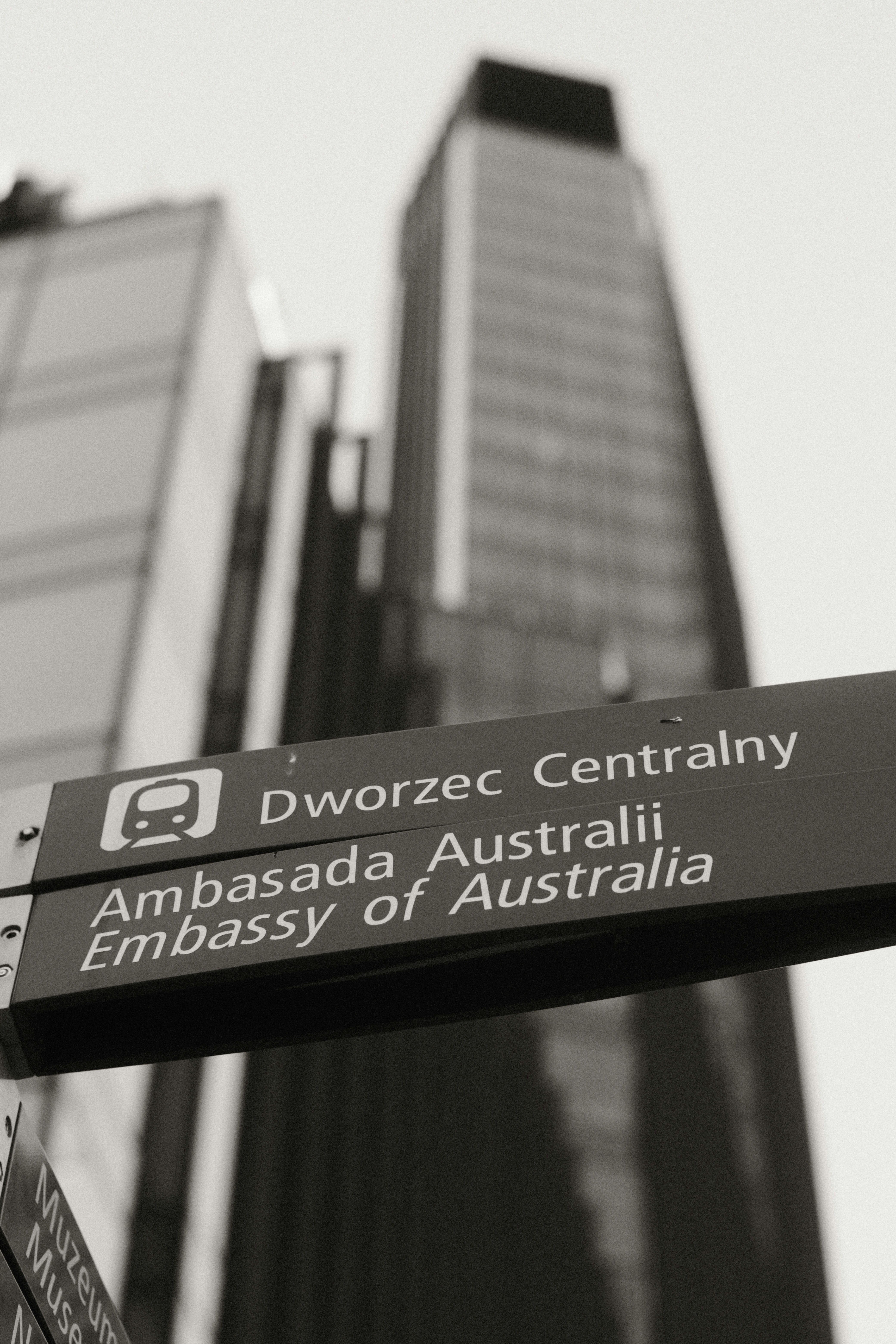 Warsaw streets, black and white. | Sign points to embassy of australia and central station.
