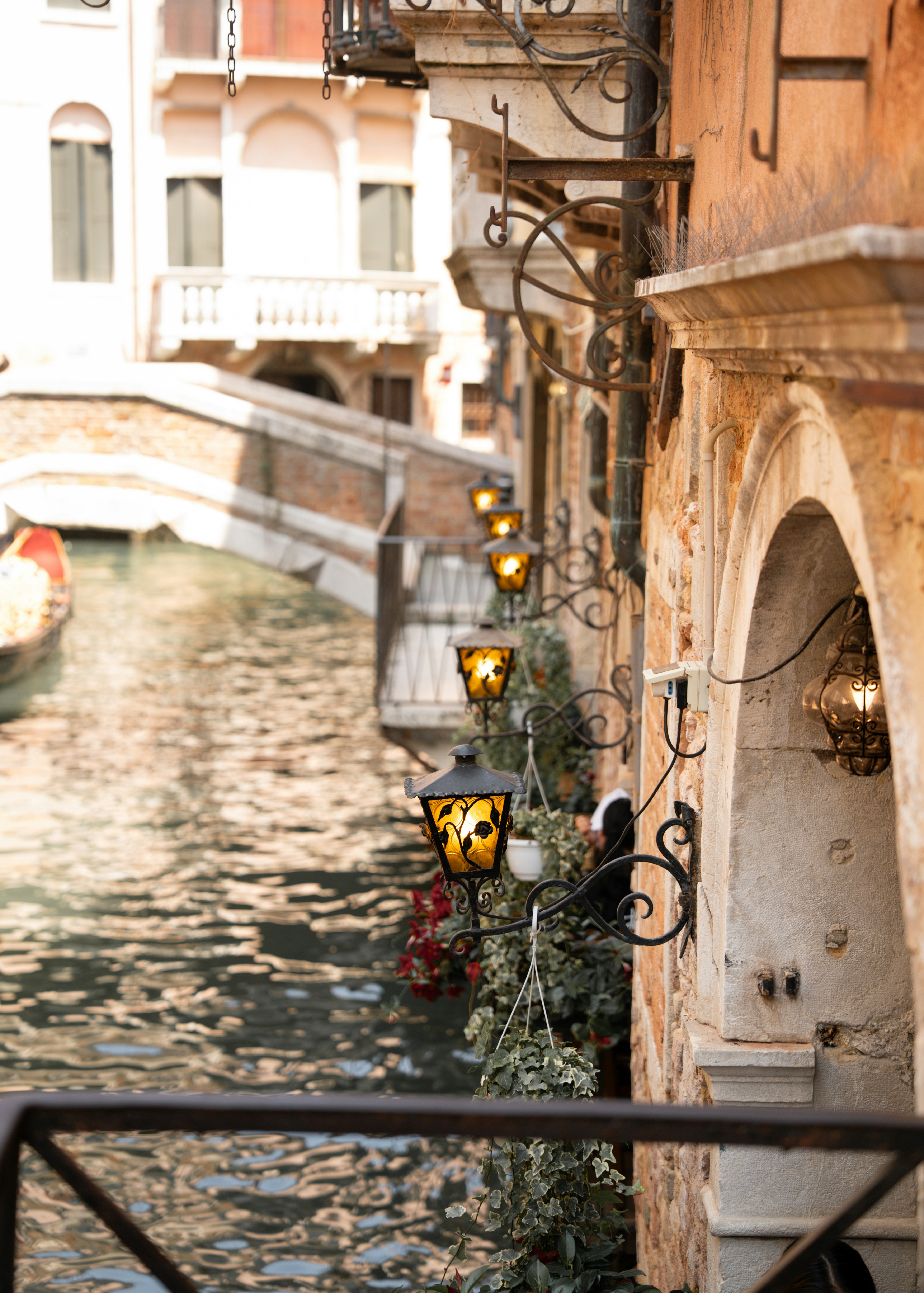 Elegant street lamps line a tranquil canal in Venice, reflecting the city's rich history and architectural beauty.