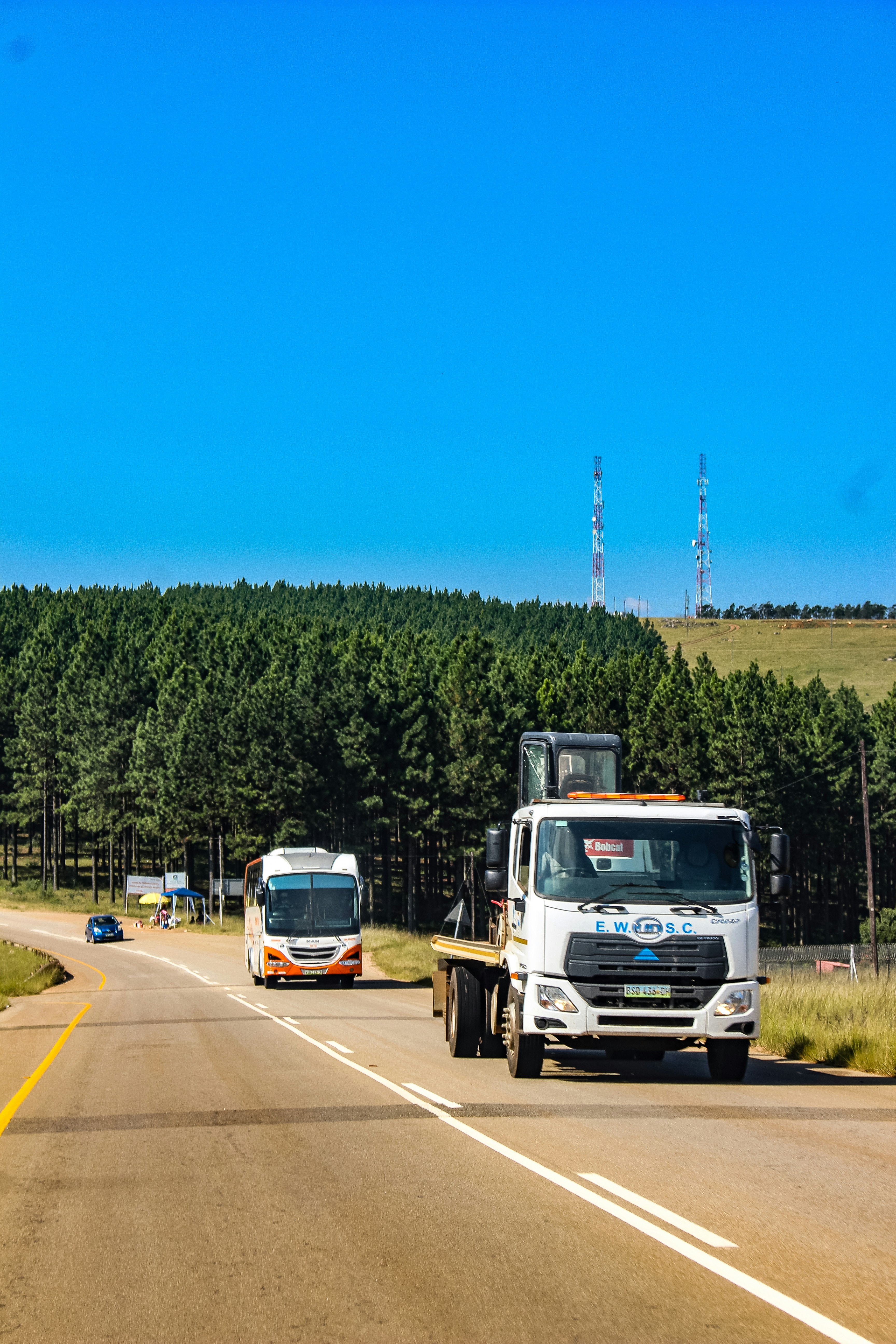 Trucks and bus traveling on a sunny road. photo – Free Car Image on ...