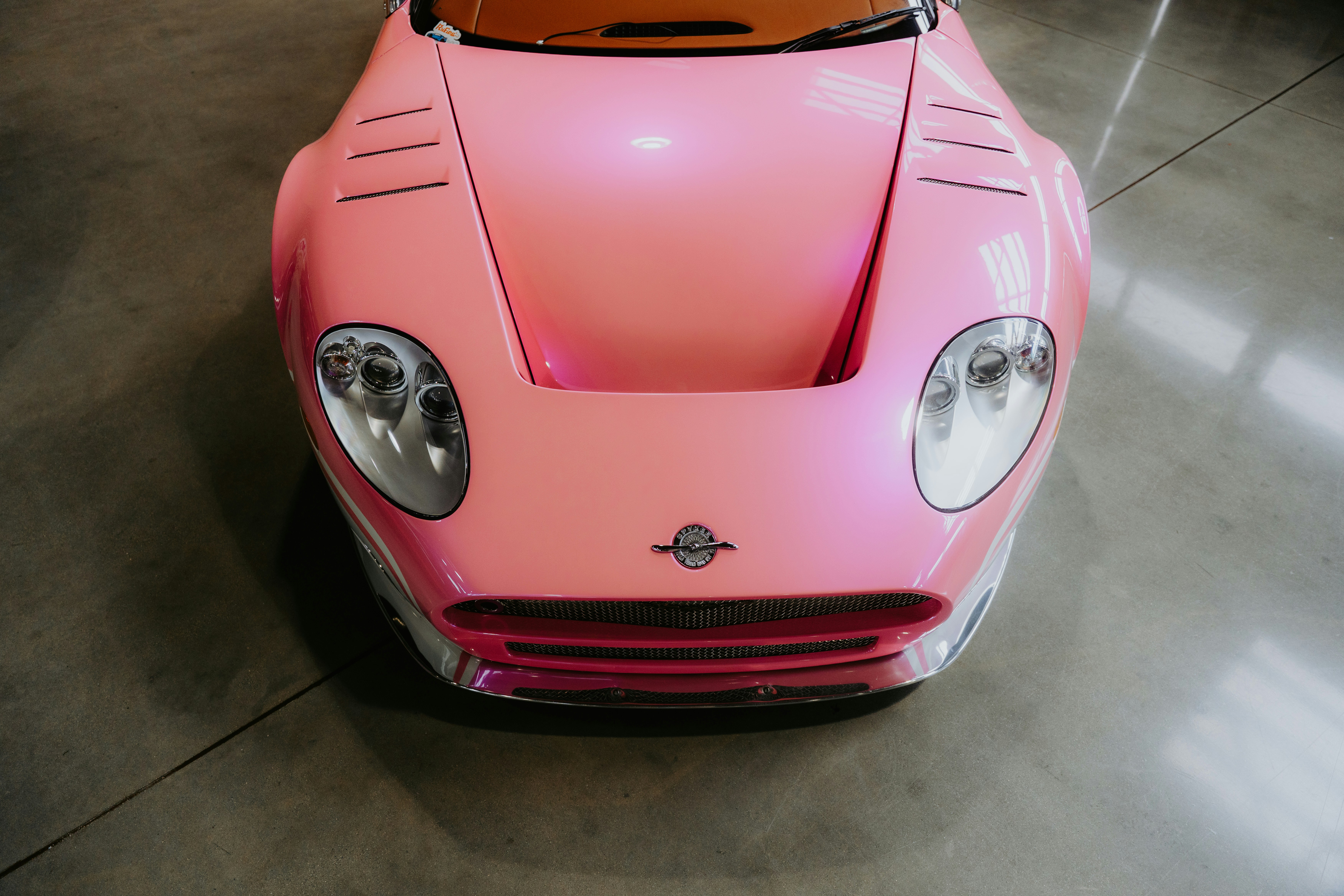 Petal Gloss: Front-View Portrait of a Pink Racer in a Quiet Gallery Garage