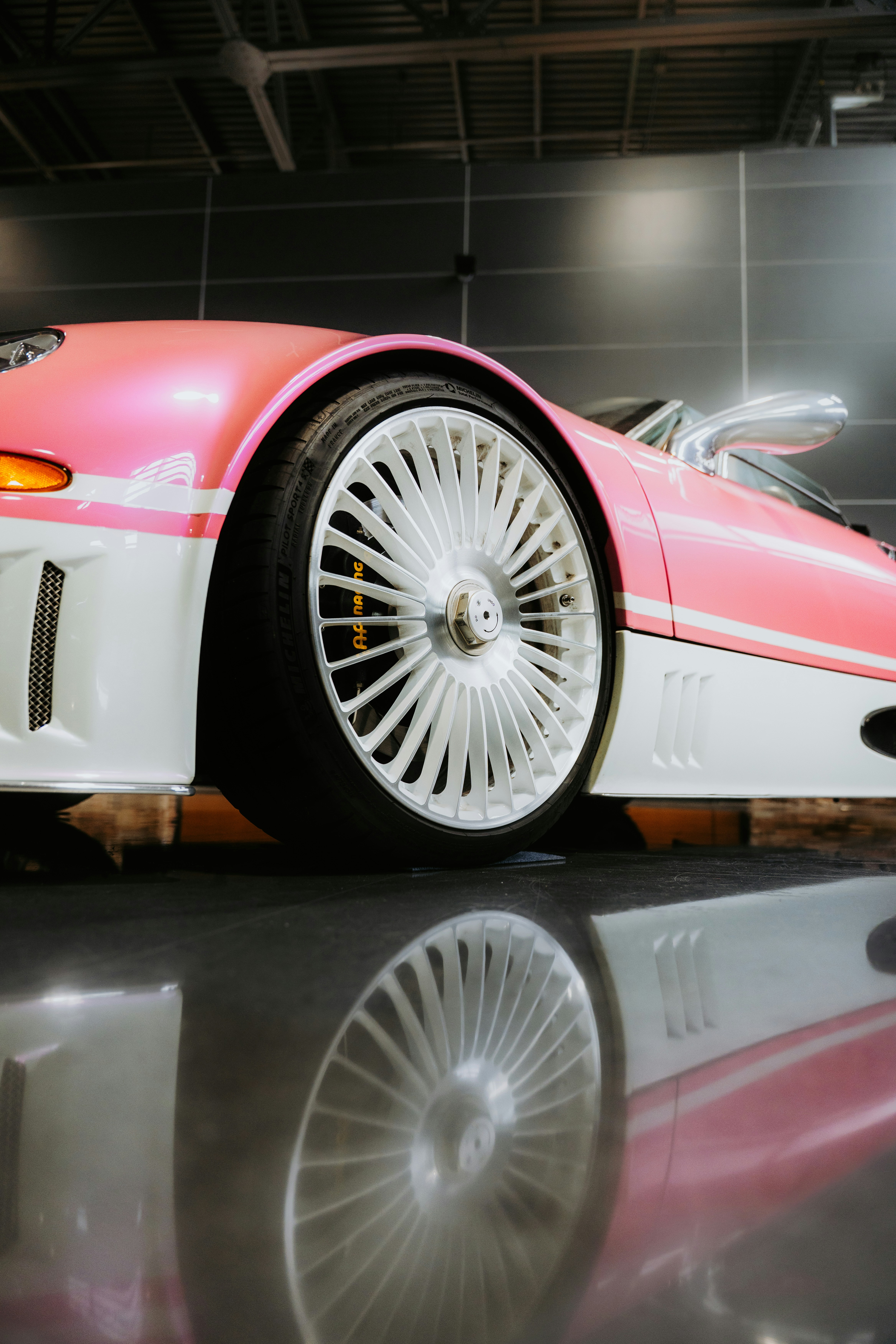 Spokes and Shine: a low-angle portrait of a pink showroom racer wheel