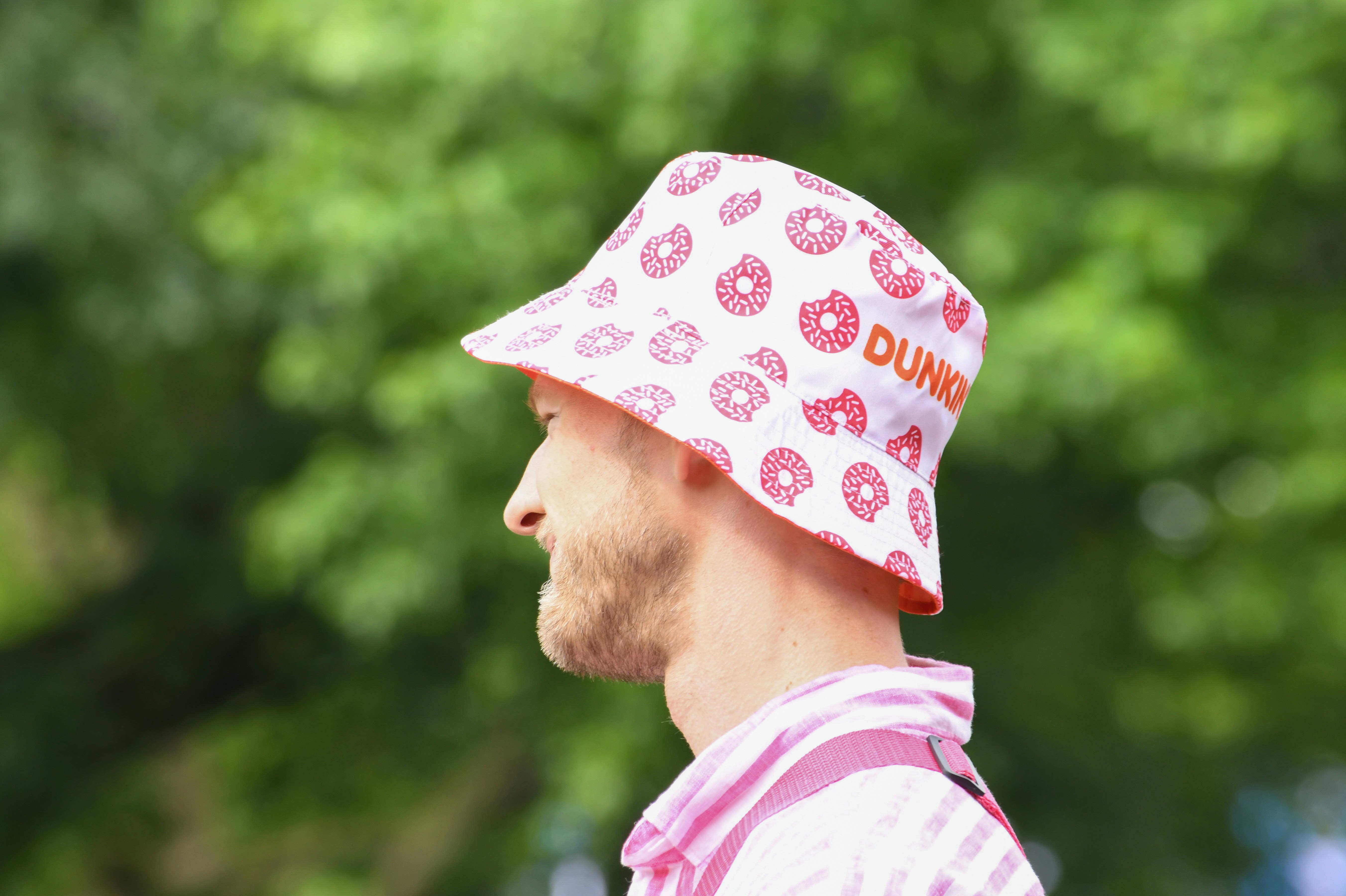 A man wears a dunkin' donut-themed hat. photo – Free Man Image on Unsplash