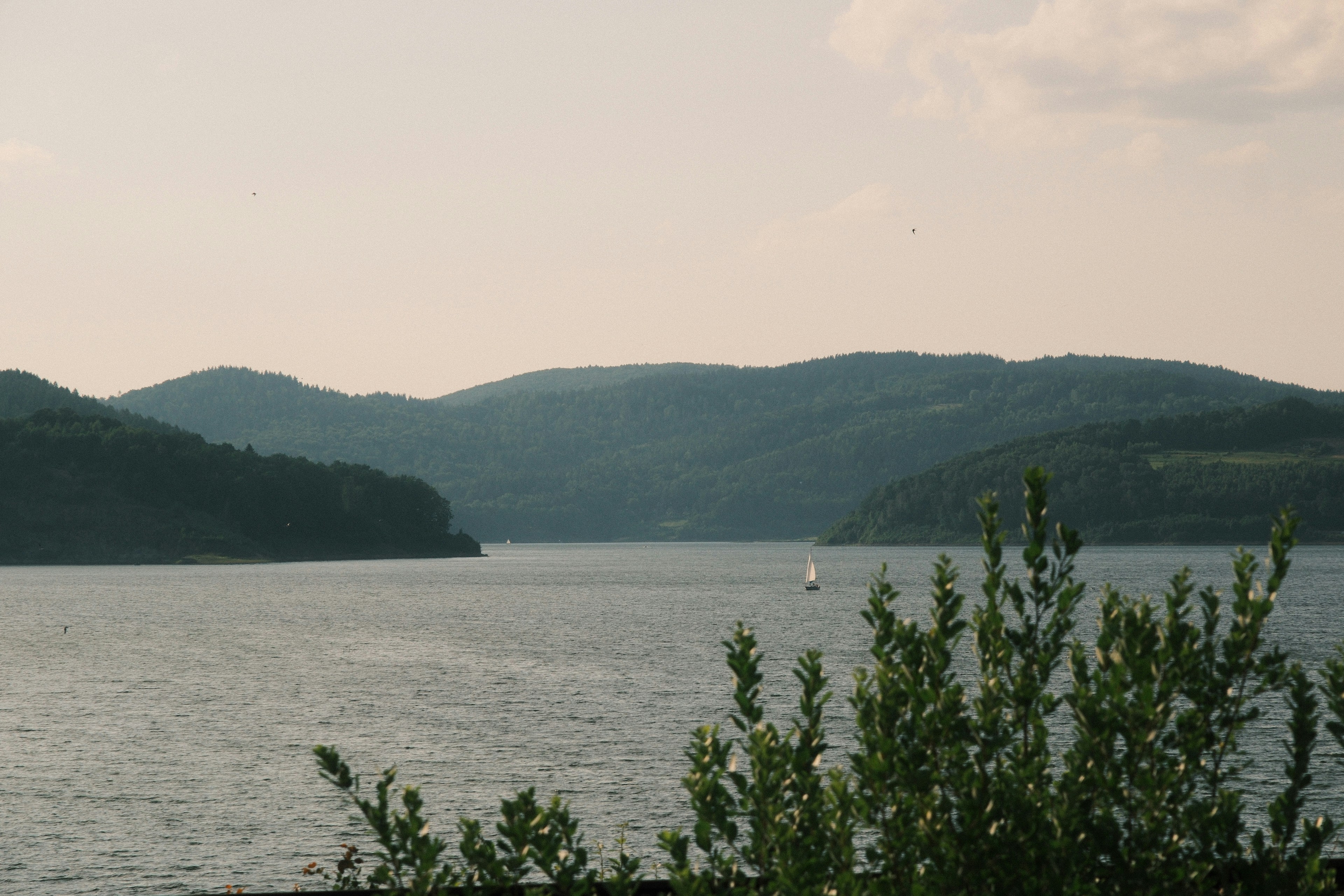 A calm lake with hills in the background.