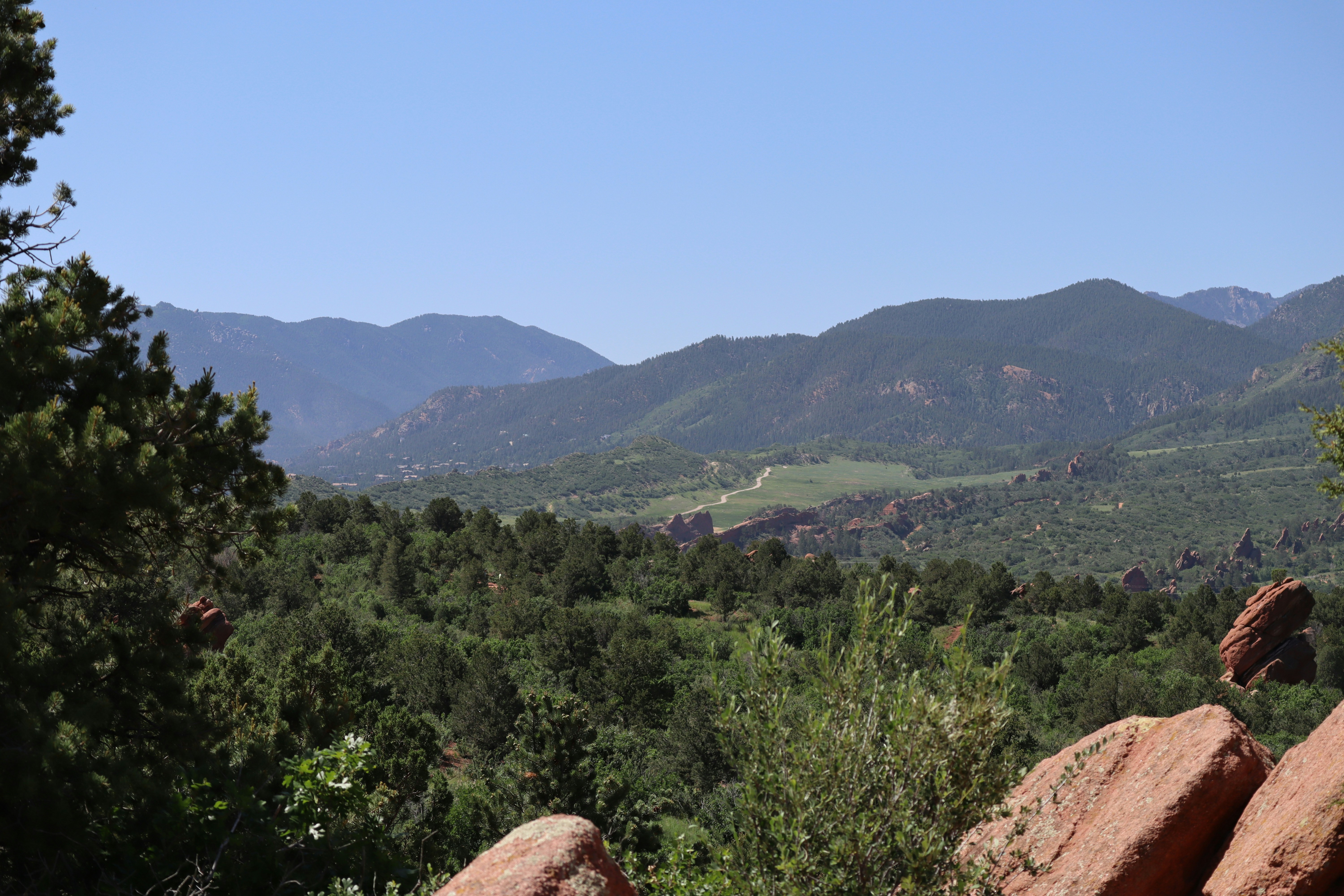 Ridgeline Quietude: Red Boulders Framing a Verdant Horizon