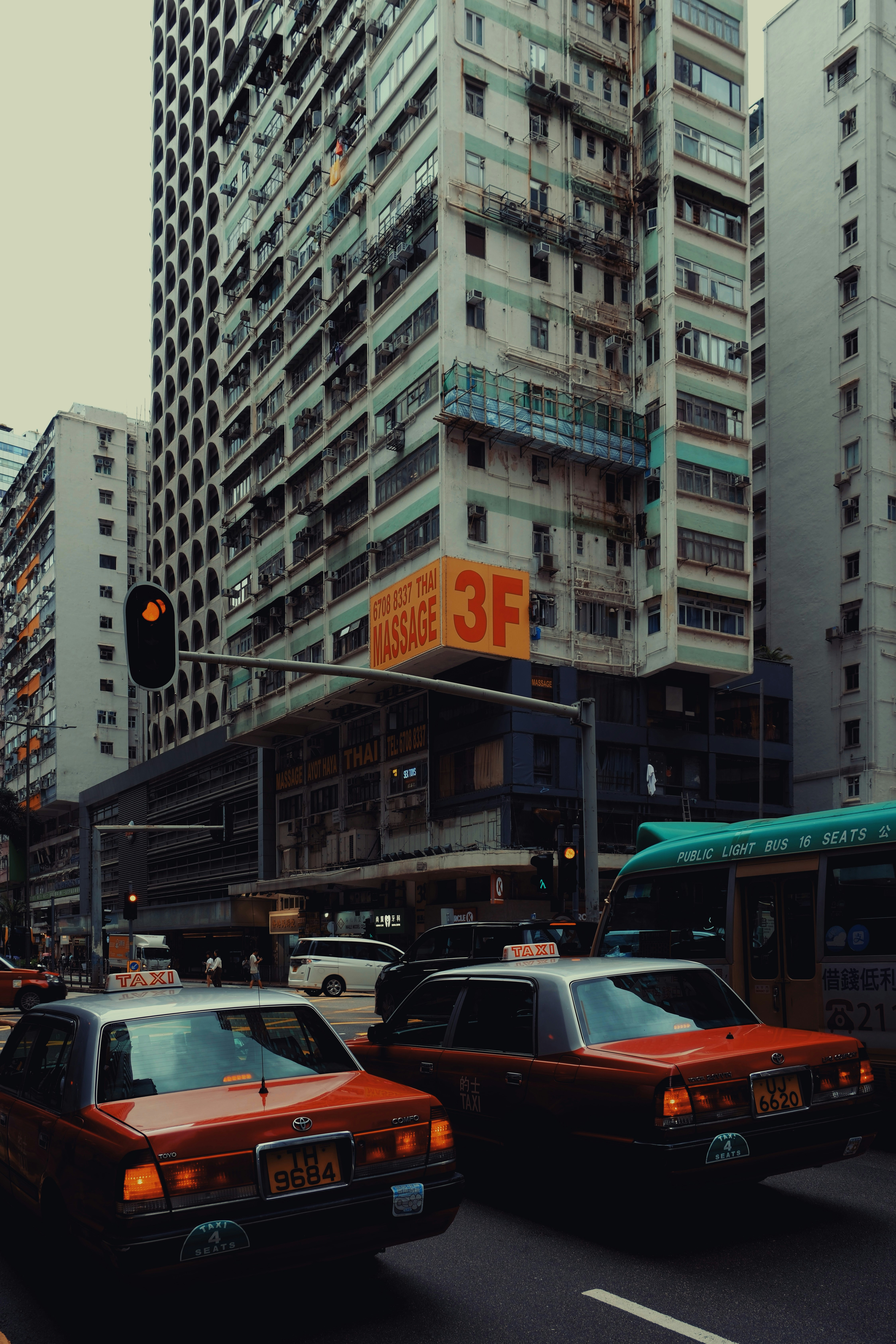Busy intersection featuring red taxis amidst towering buildings and vibrant signage. A snapshot of urban hustle.