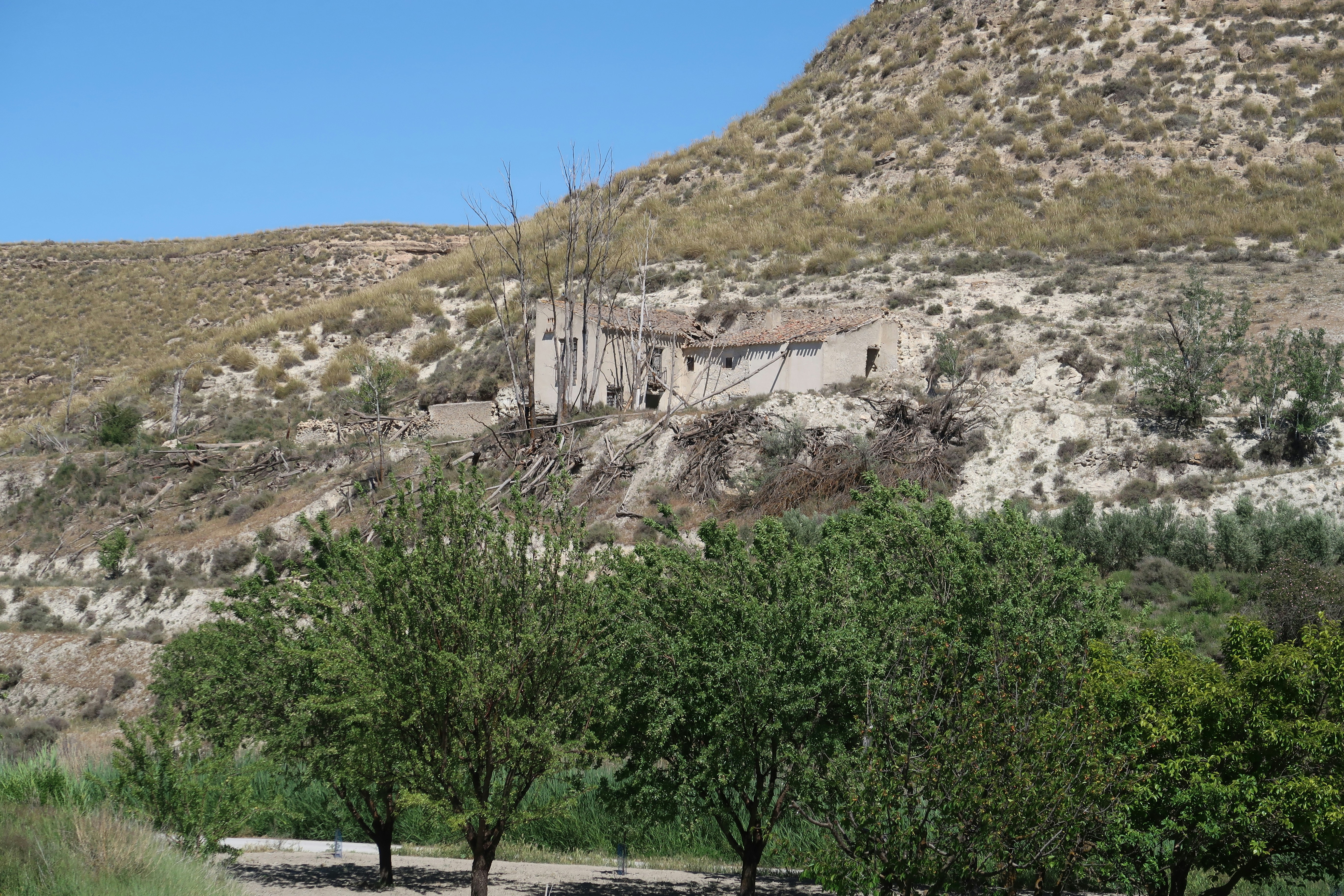 paisajes del altiplano granadino | Ruined buildings nestled into a hillside.