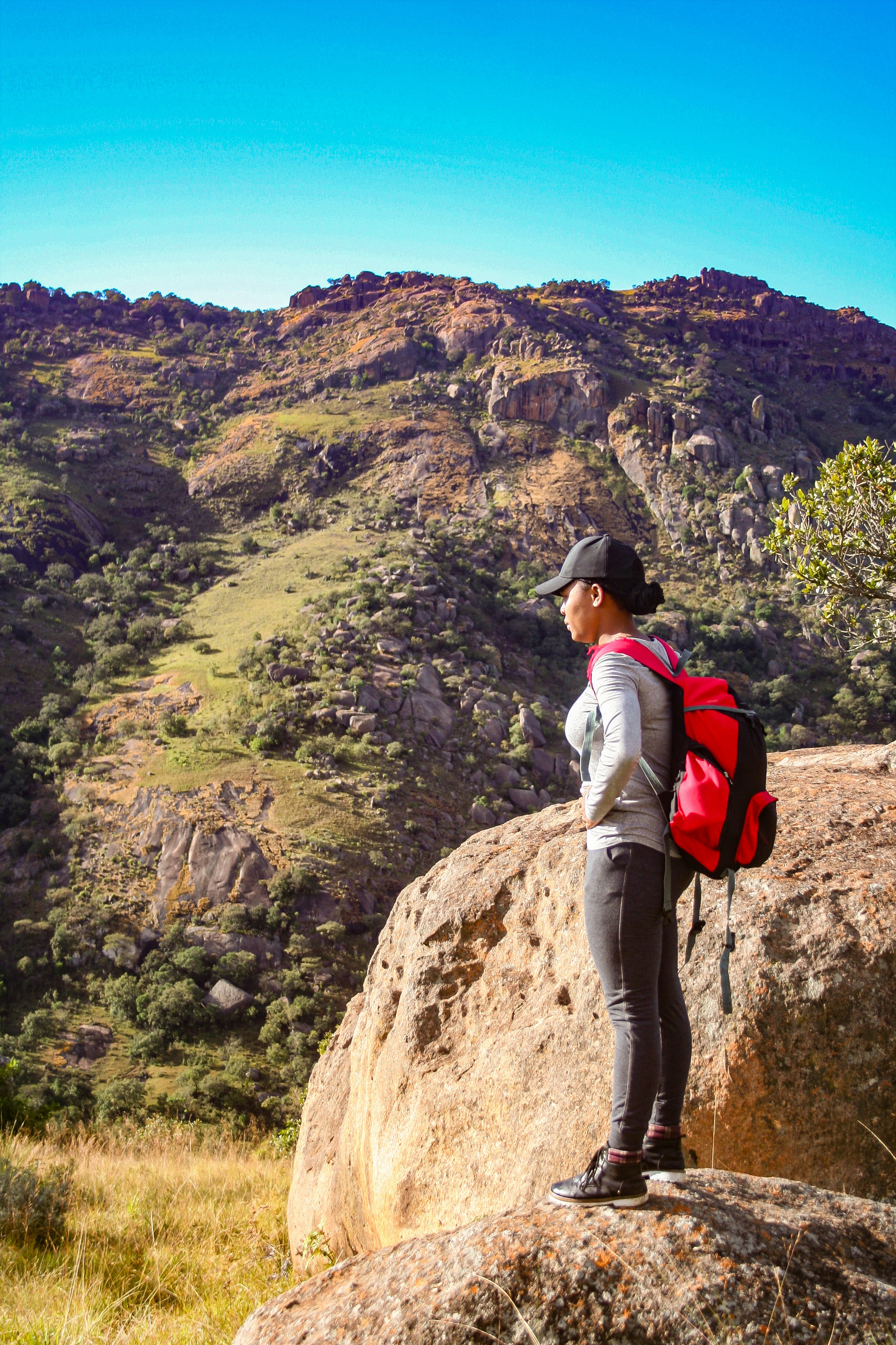 Edge-Watch on the Ridge: Hiker with Red Pack at a Sunlit Overlook