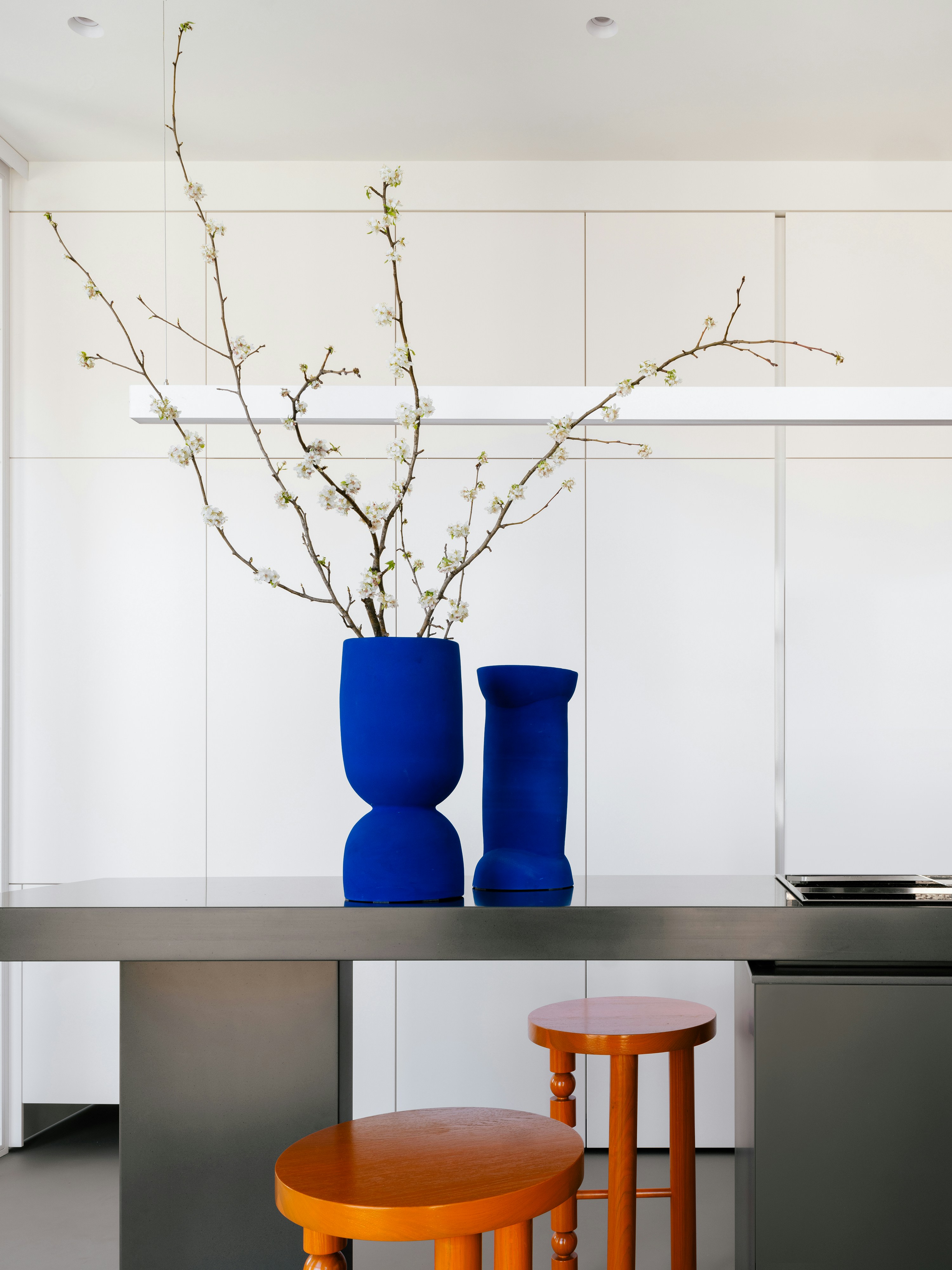 Jarrones azules brillantes con ramas florales en la encimera. foto ...