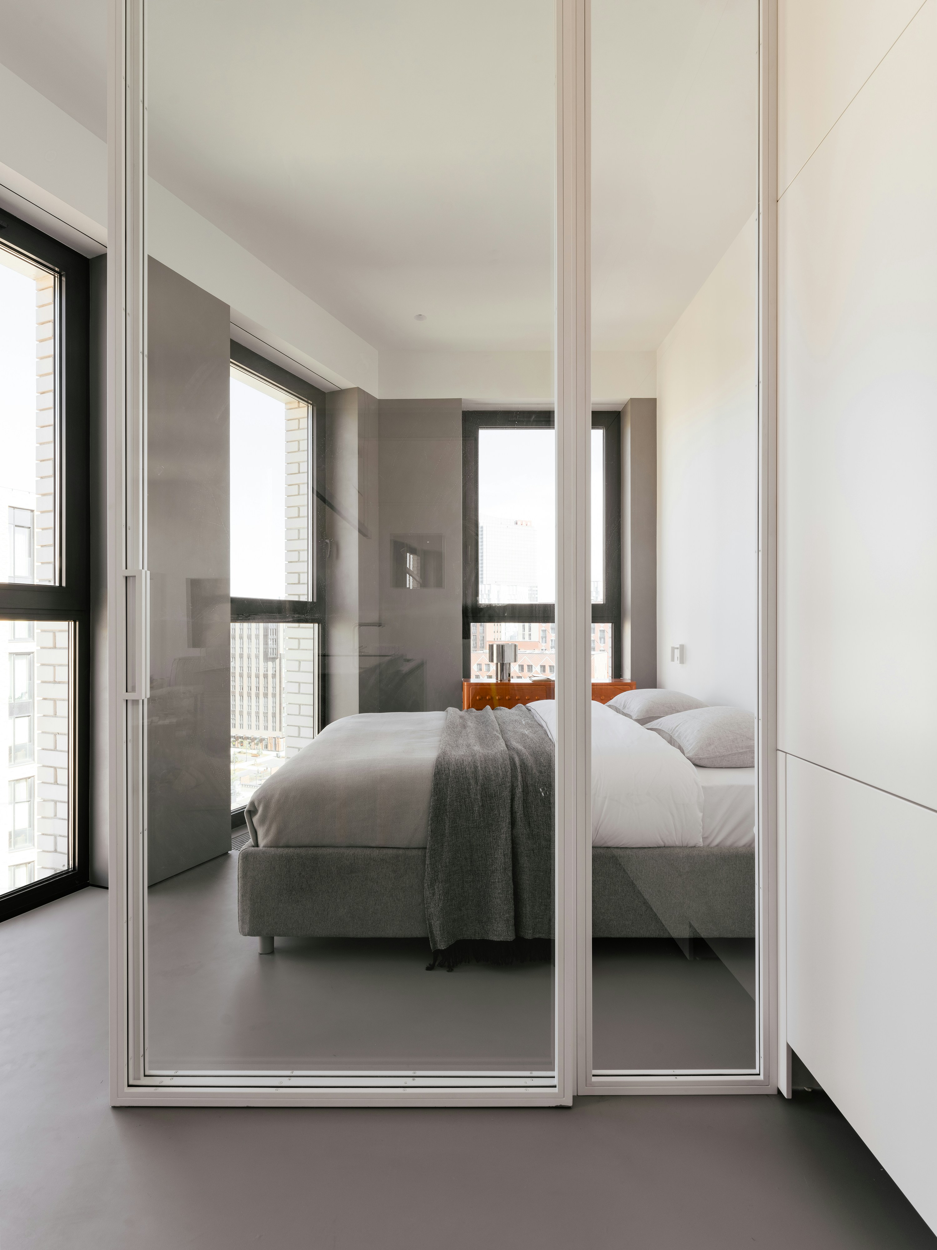 A modern bedroom is viewed through a glass door.