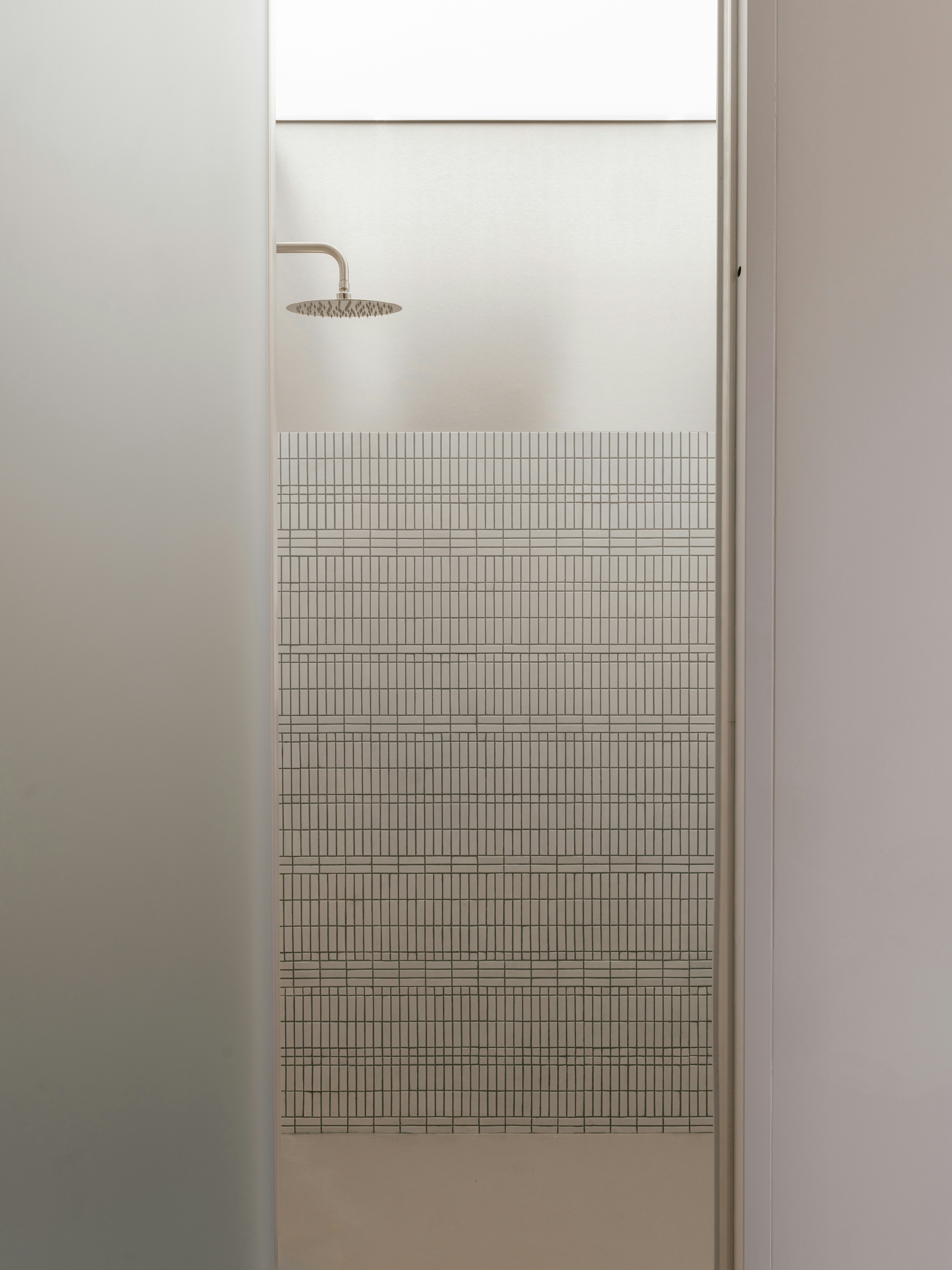 A shower head and grid wall is visible.