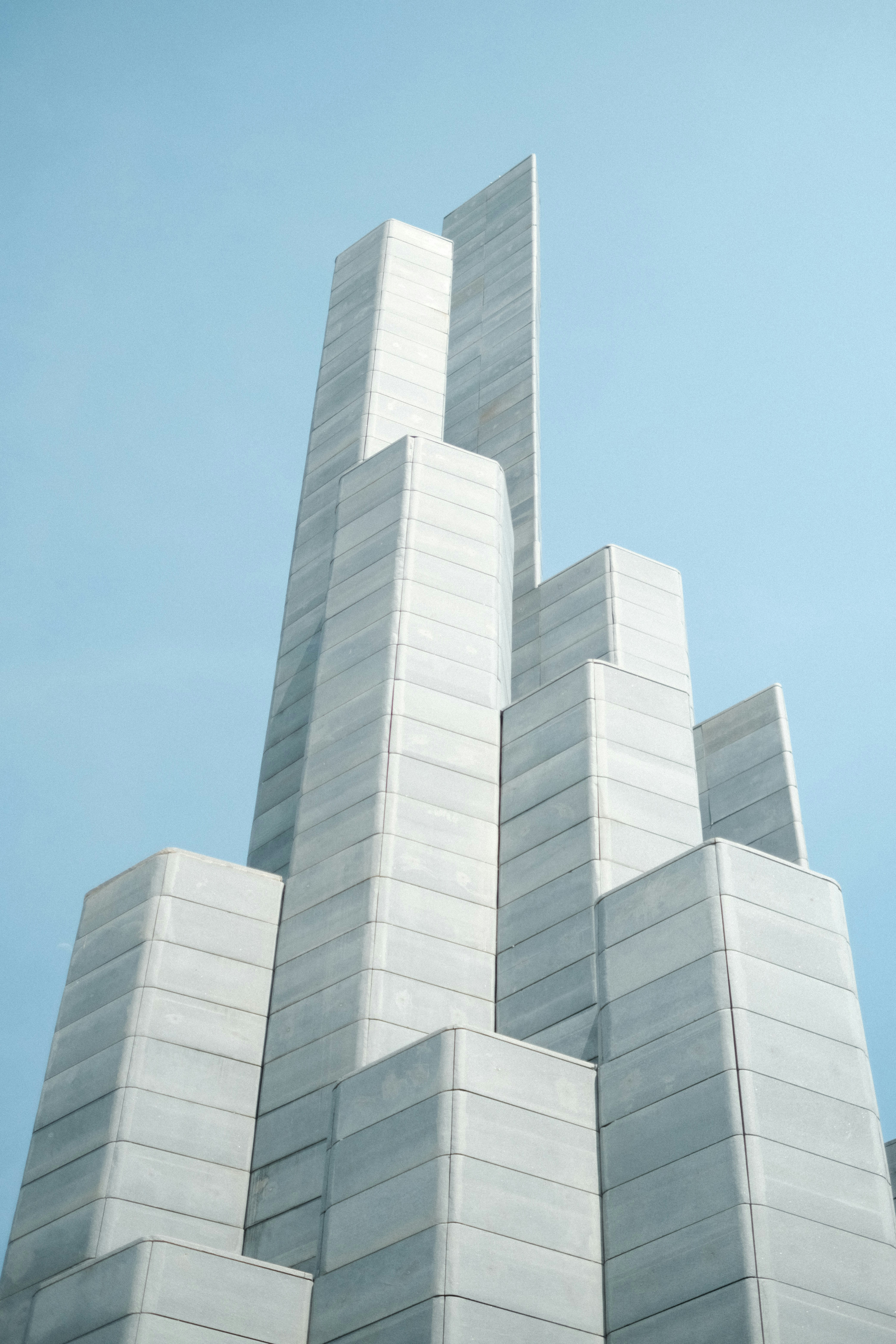 Modern concrete building stands tall against blue sky.