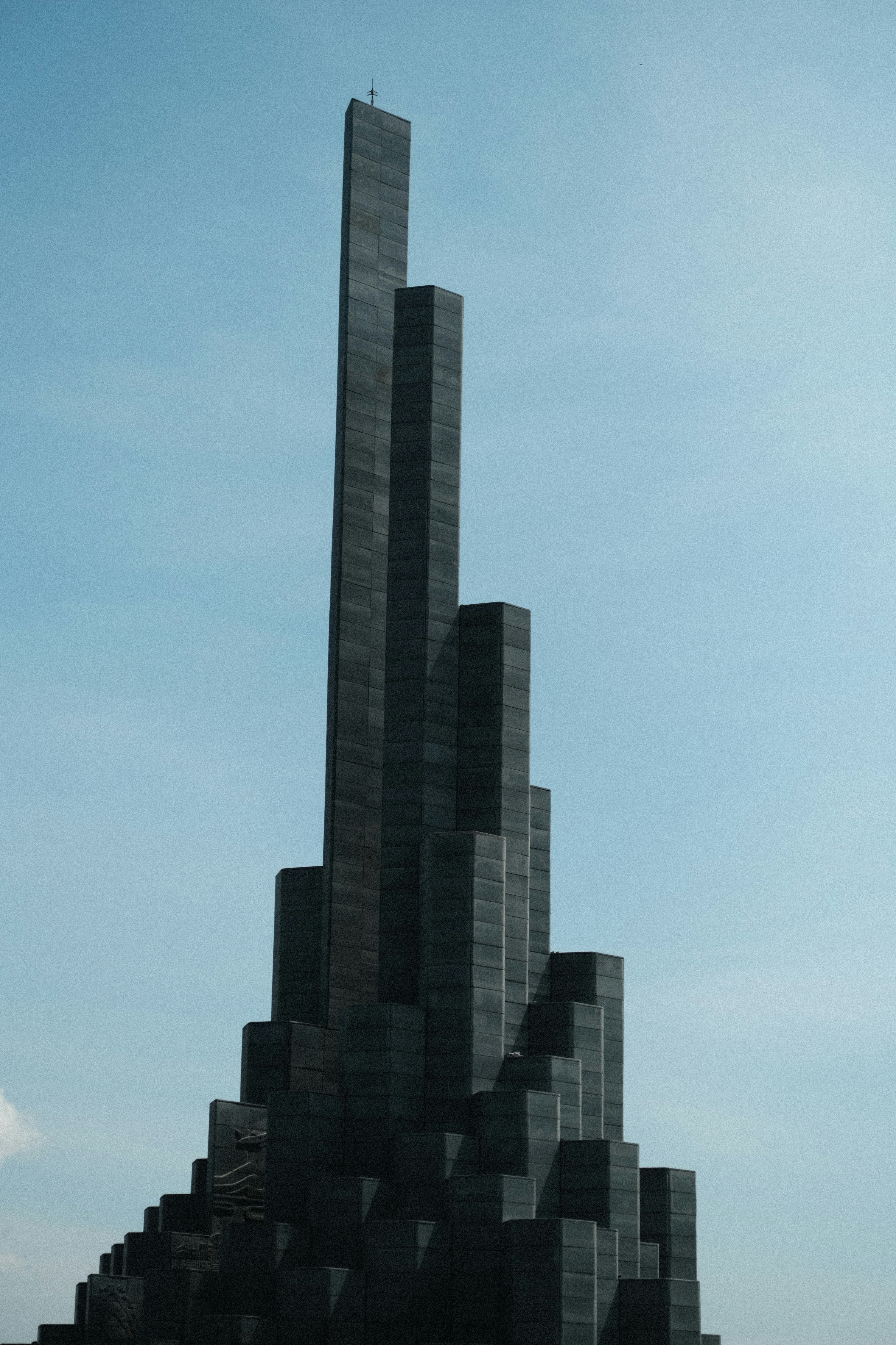 A tall, angular monument stands against a blue sky.