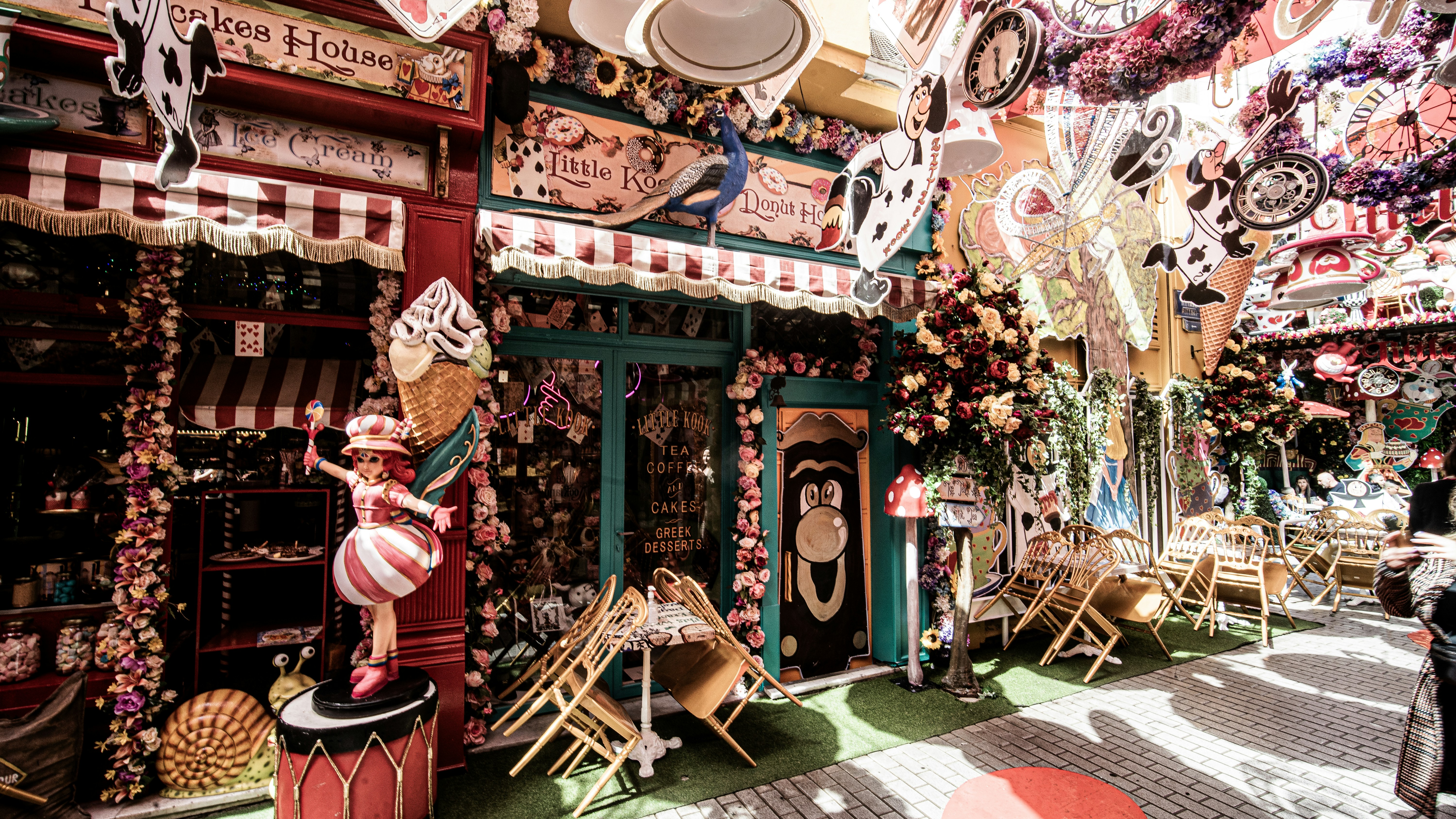 A vibrant street scene adorned with colorful decorations, featuring a whimsical ice cream stand and playful floral arrangements. The lively atmosphere invites exploration.